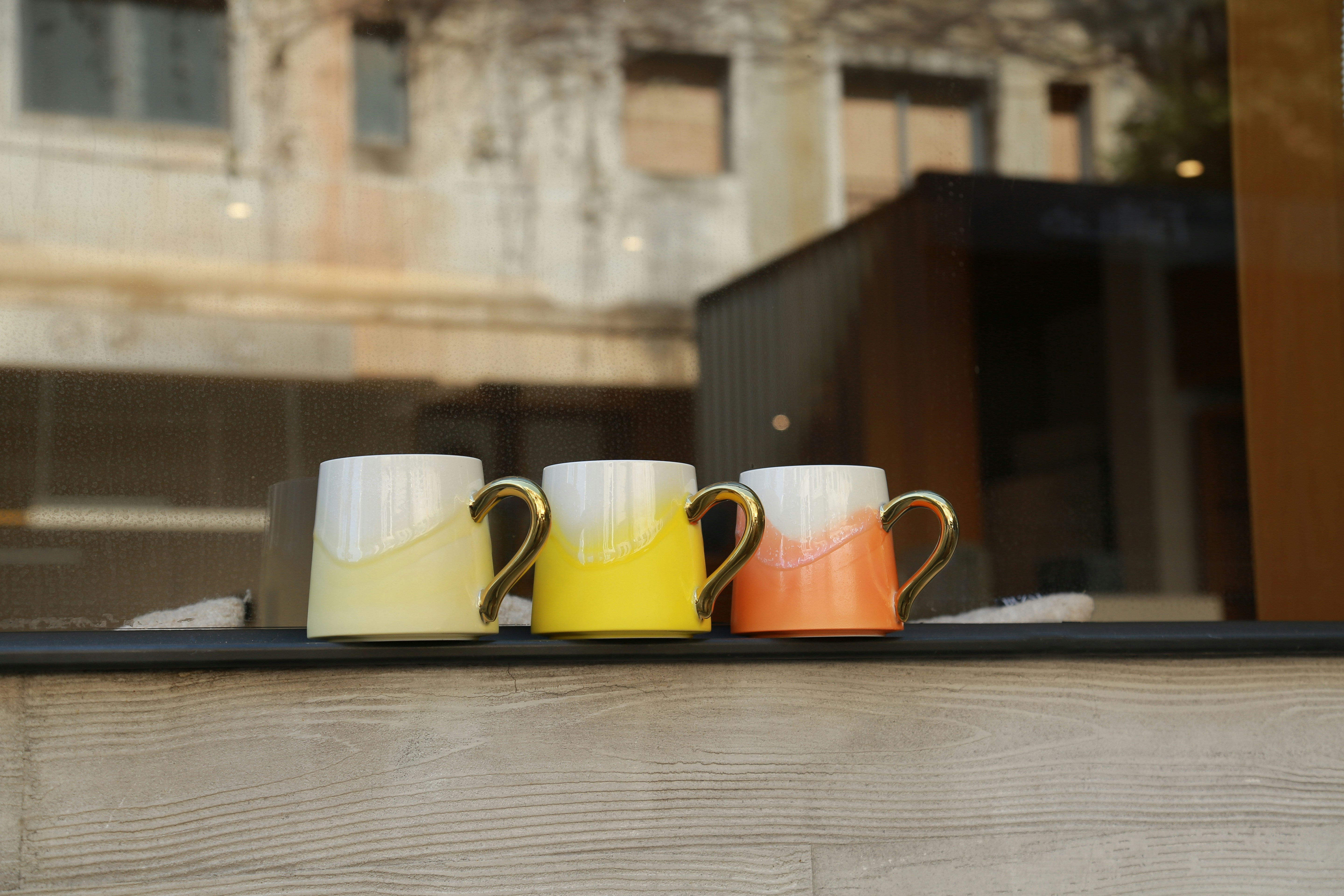Ceramic trio on a weathered ledge under storefront light