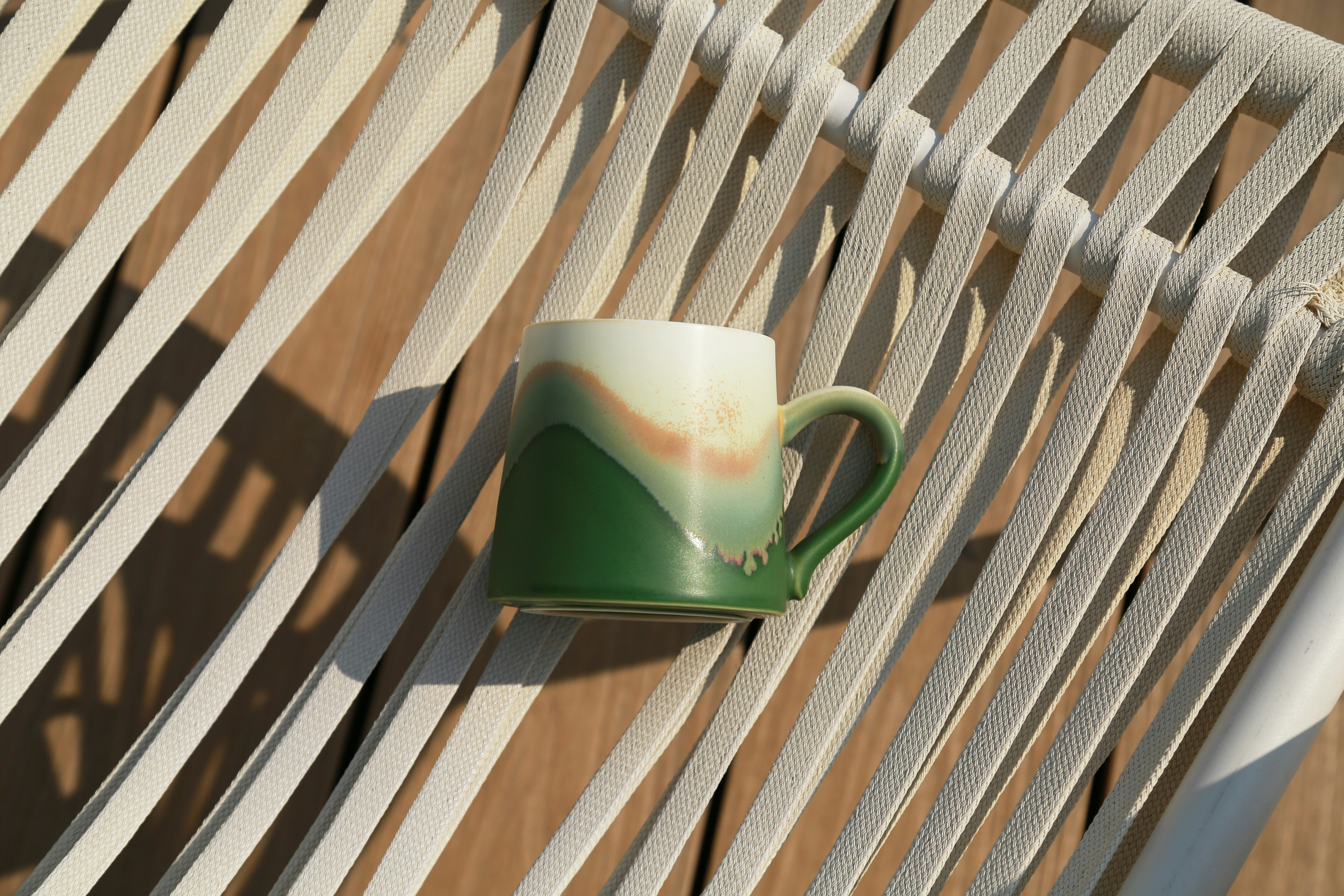 Handcrafted pottery coffee mug featuring artistic glaze patterns inspired by landscapes and natural colors. Contemporary ceramic craftsmanship with a timeless aesthetic.