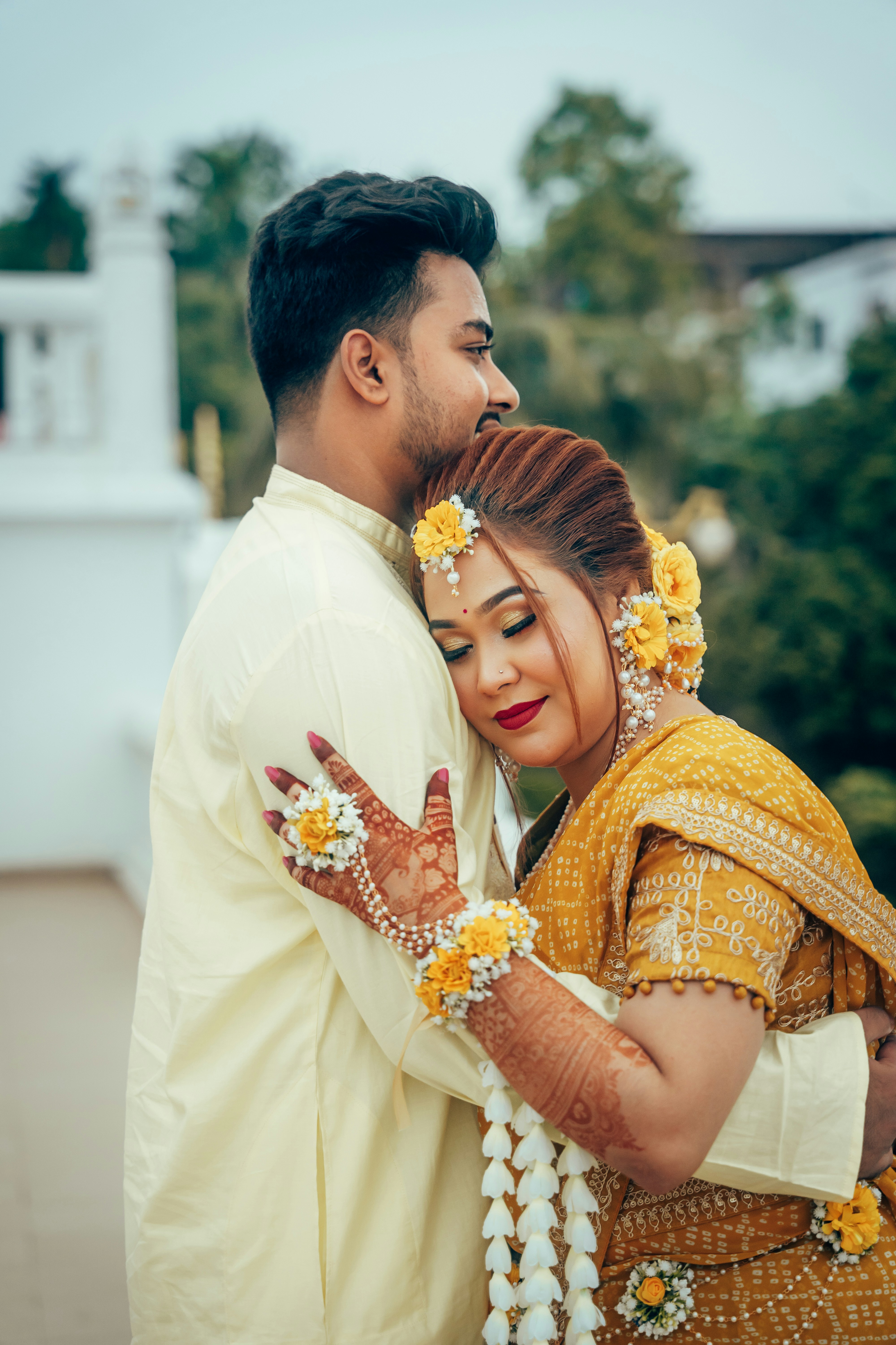 Embrace in Yellow: A Wedding Moment Steeped in Henna and Floral Glow