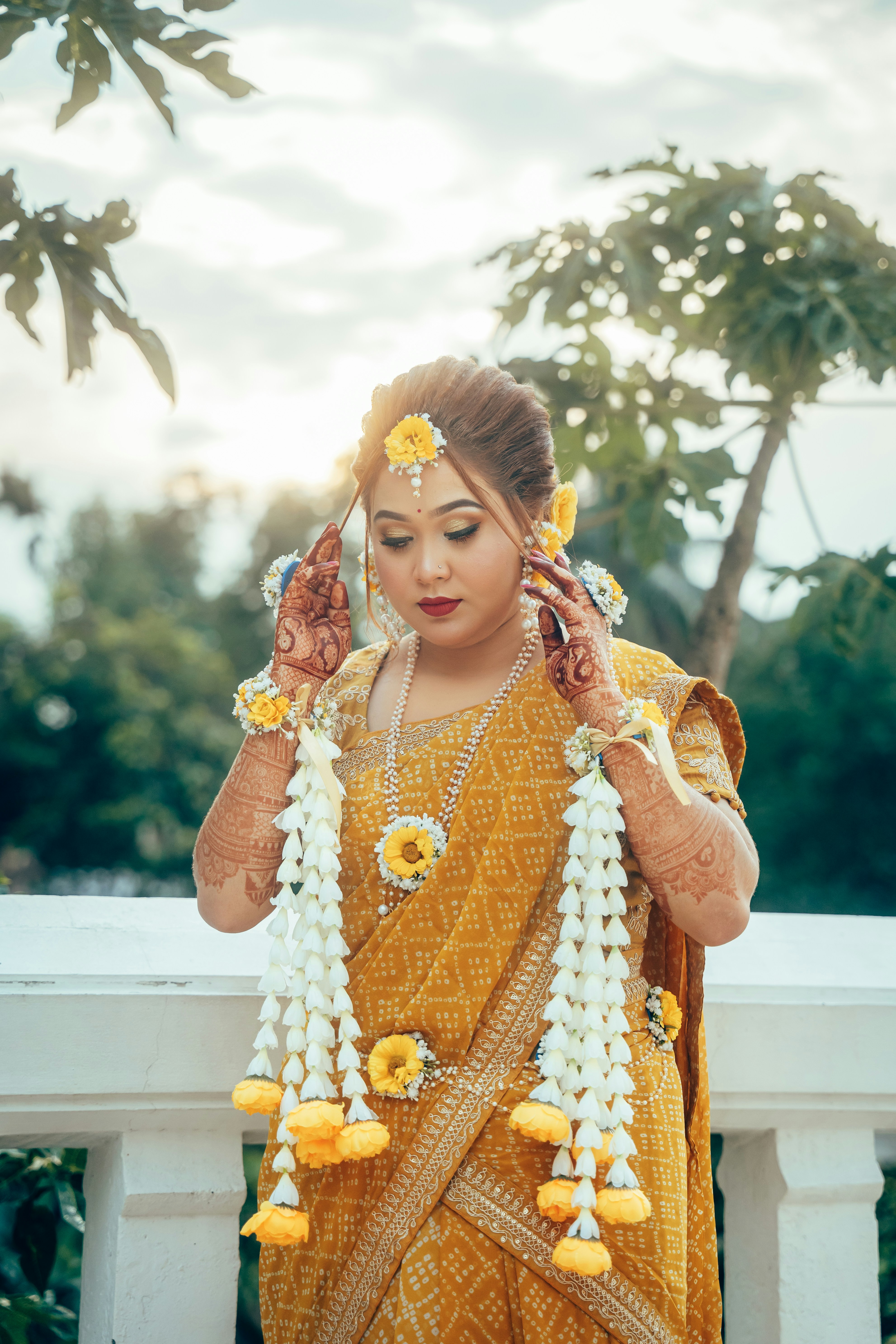 Golden ceremonial portrait: a bride in yellow silk and jasmine garlands