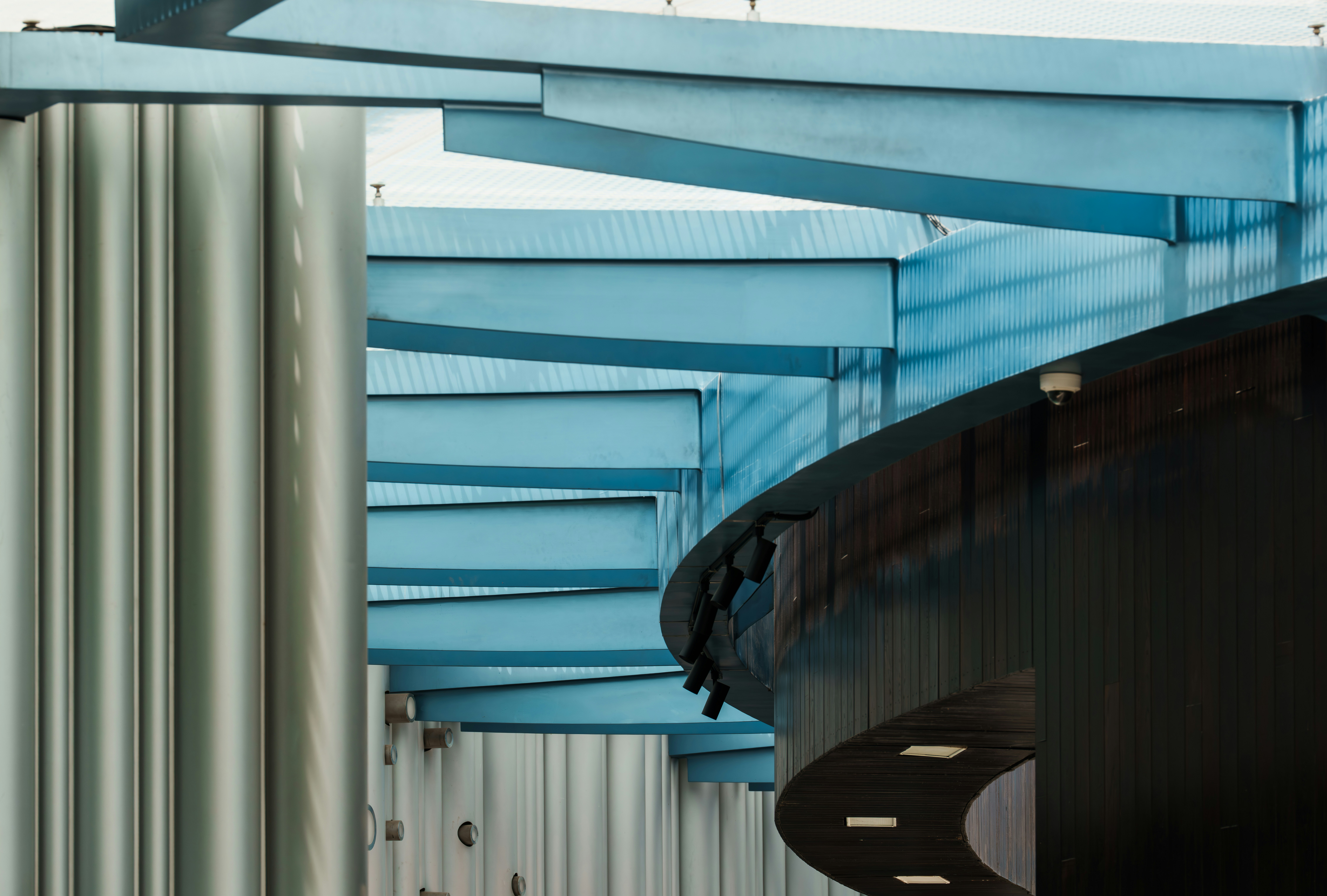 Modern abstract architecture with blue beams and curved structures.
