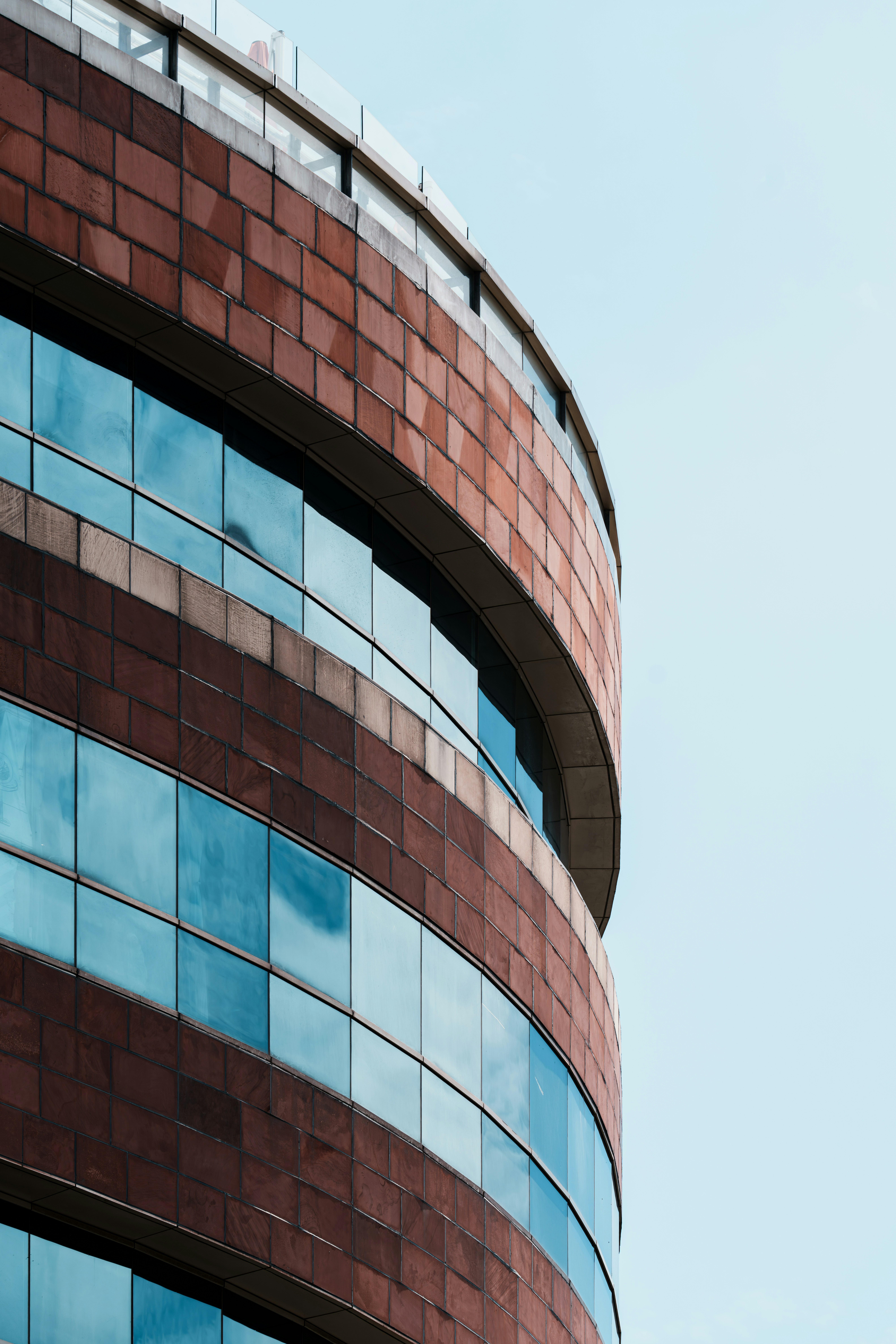 Curved Glassed Facade: Circles of Red Brick and Sky
