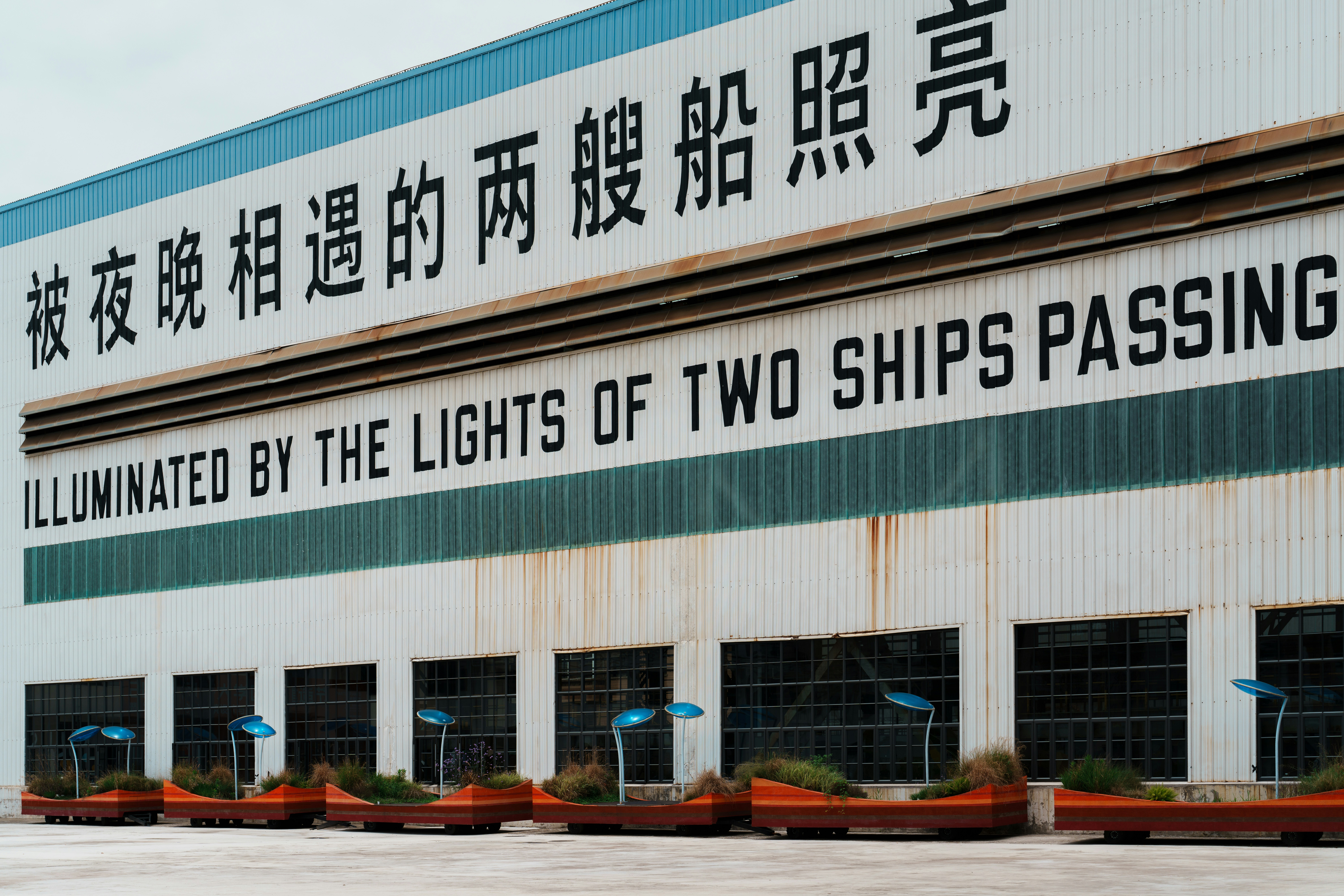 Illuminated Hangar: Two Ships' Quiet Command over Distant Rails