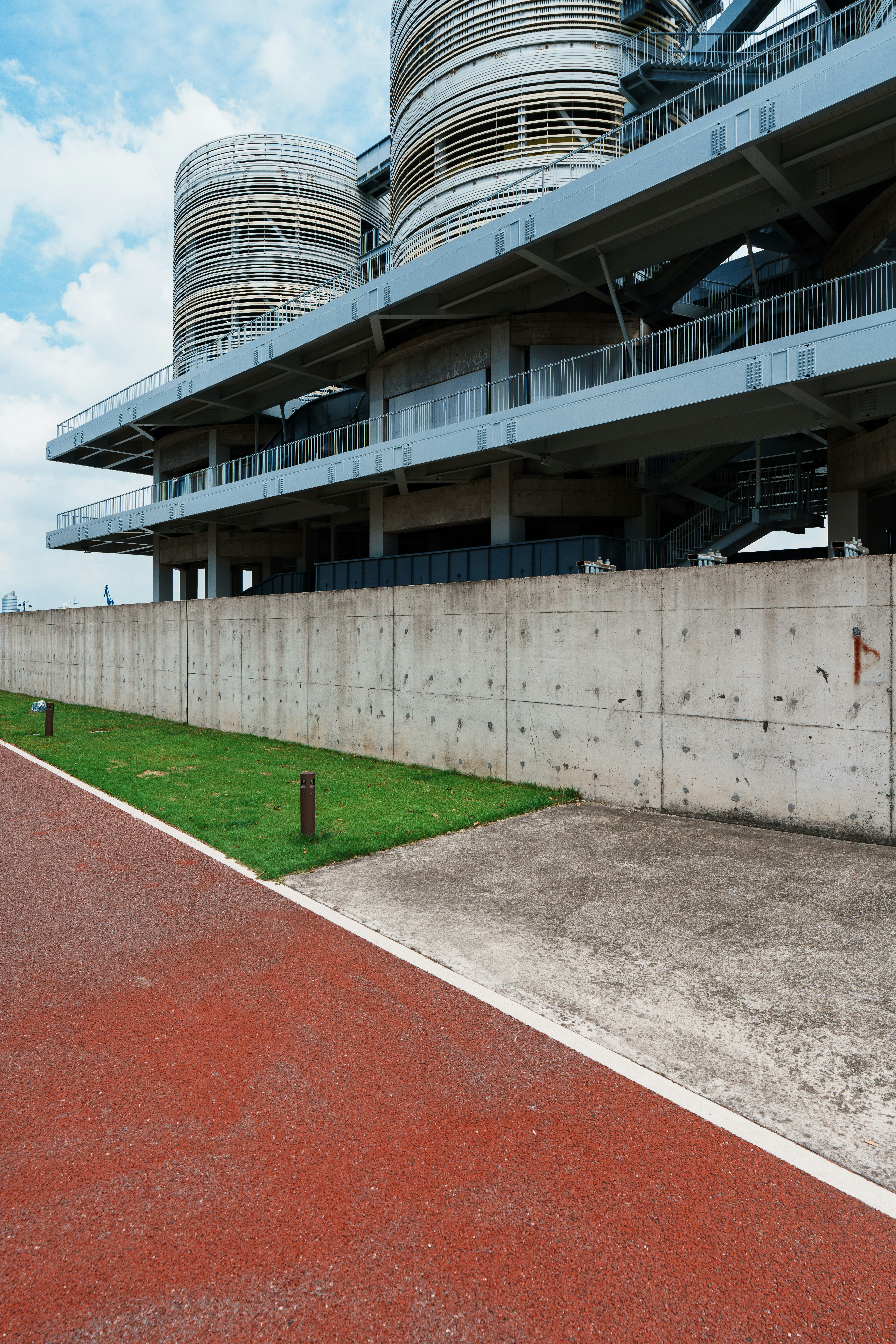 Concrete Barrier and Tiered Circles: A Stadium Structure Rises Over Red Track