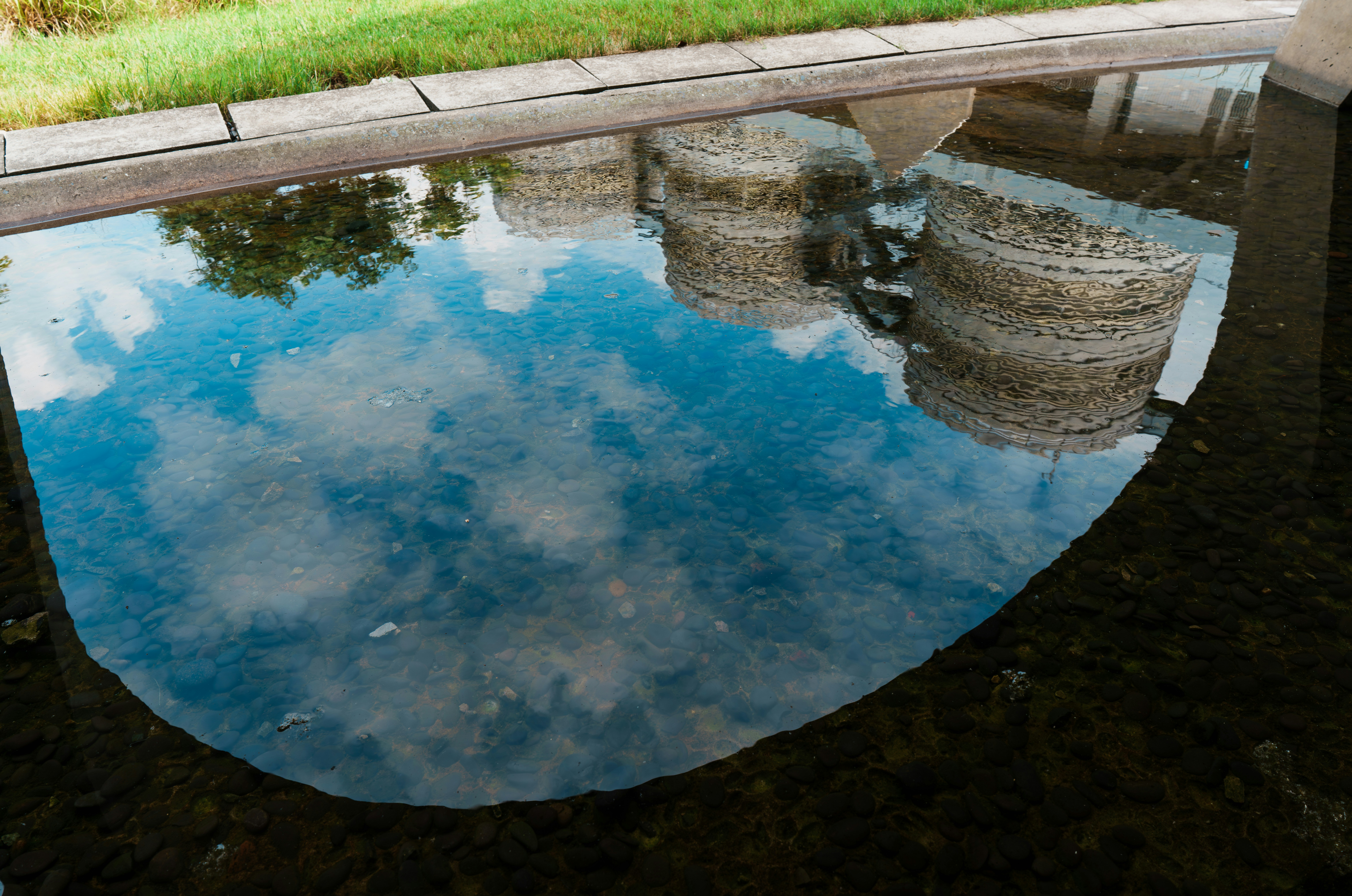 Reflected Arch: Sky and Cloud Curve in a Courtyard Pool