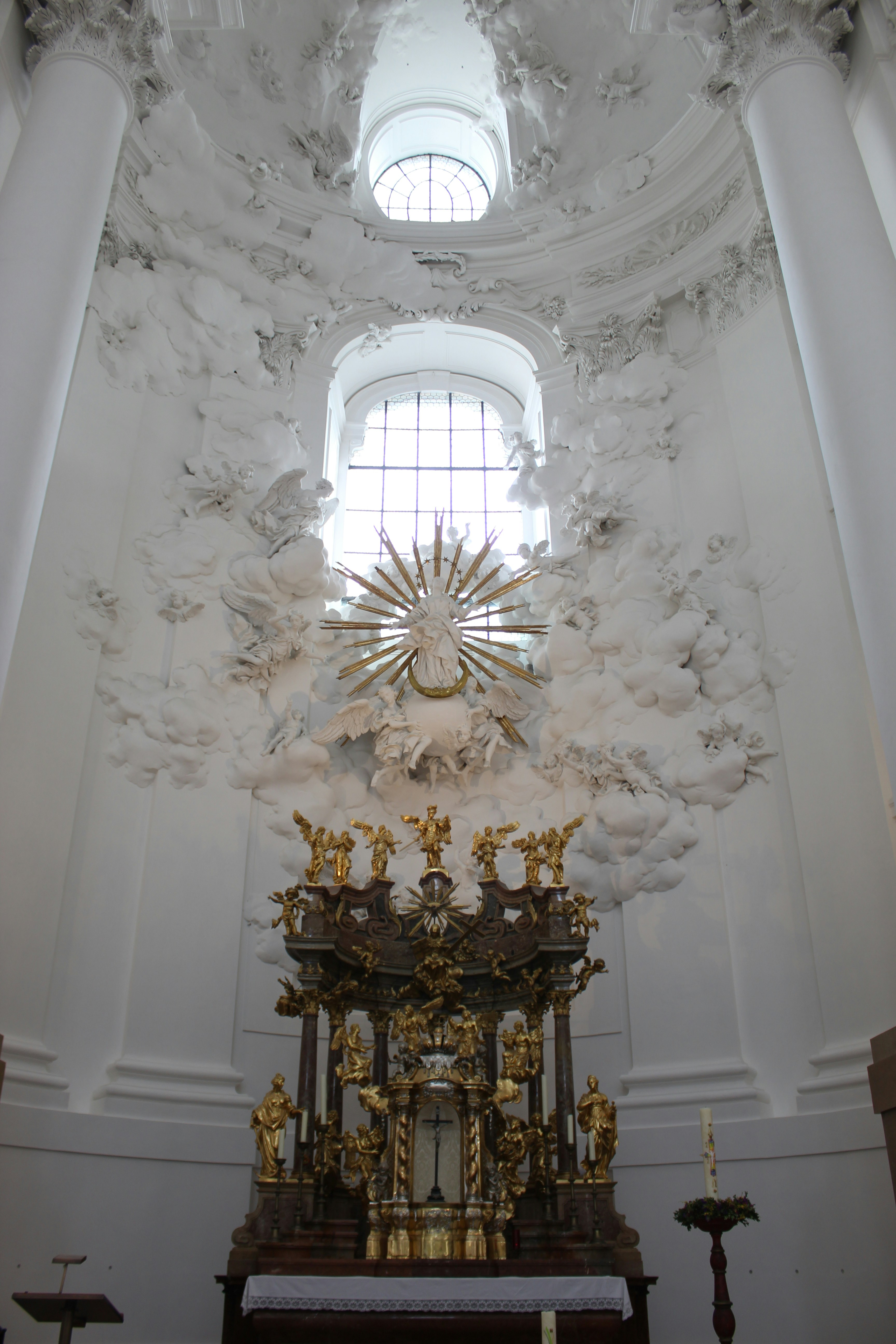 Gilded altar beneath a sunburst of light in a Baroque chapel