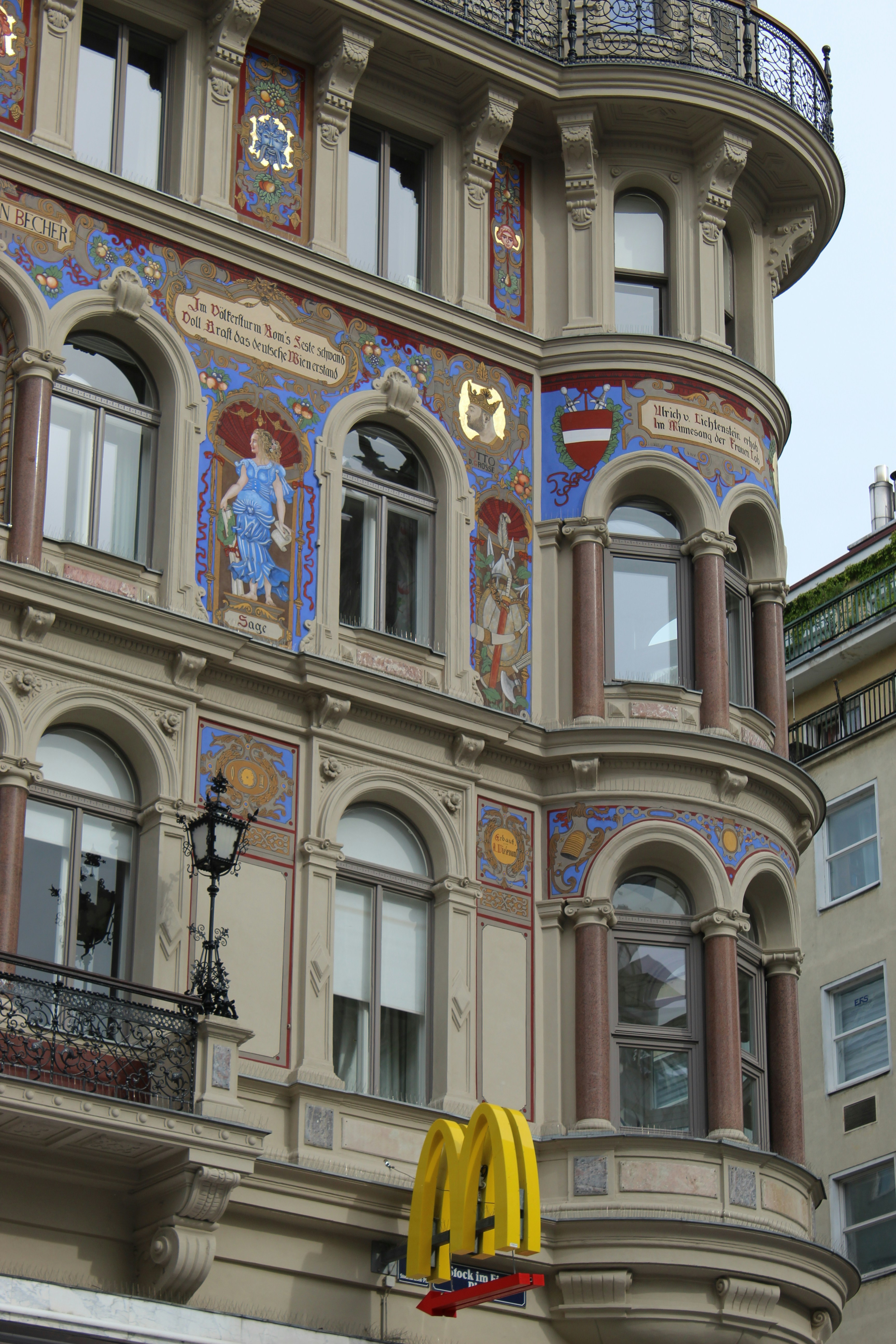 Ornate Facade with Gold Arch and McDonald’s Sign Peppering the Corner