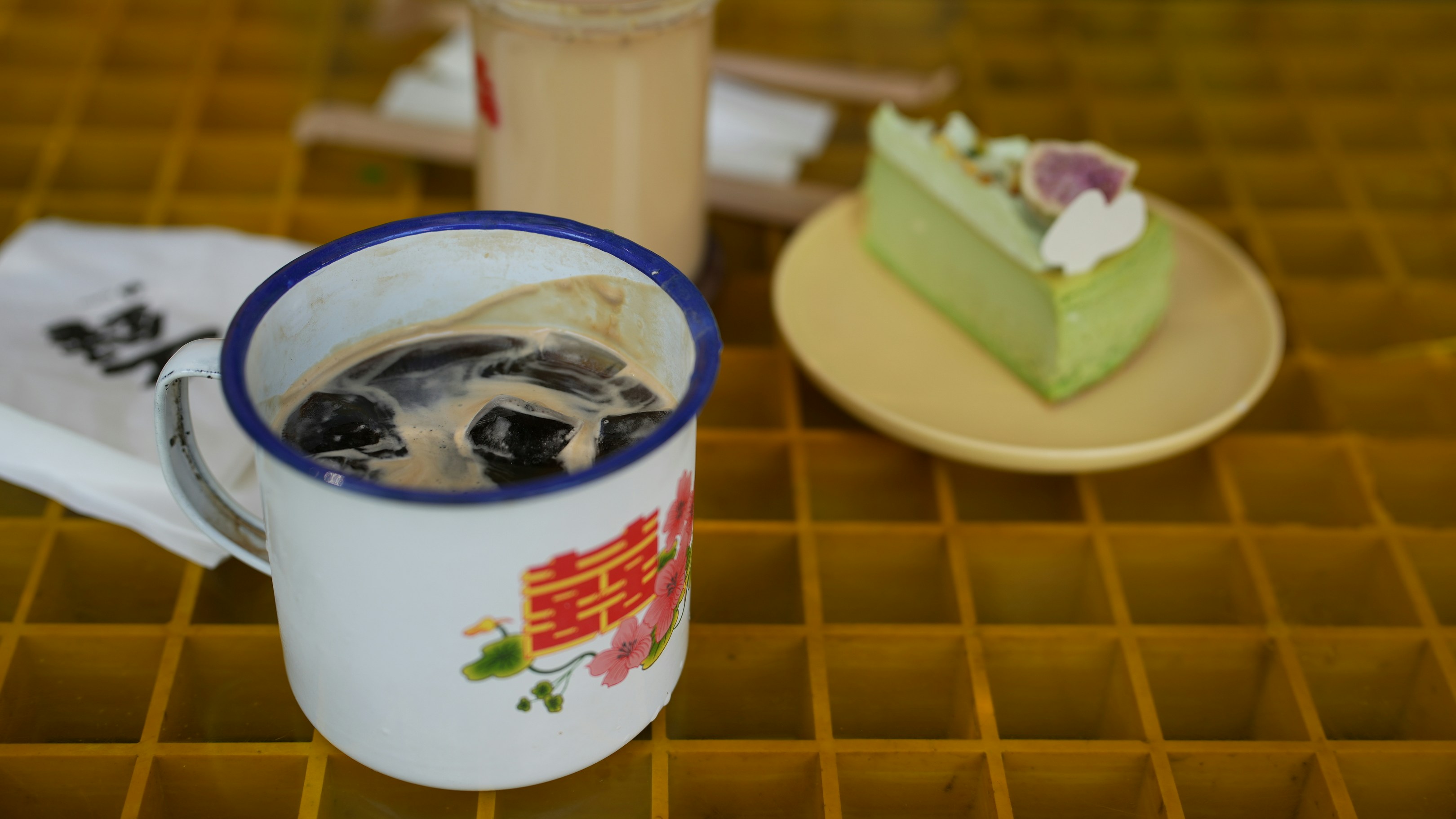 Morning Café Scene: Coffee Cup and Green Slice on a Tiled Table