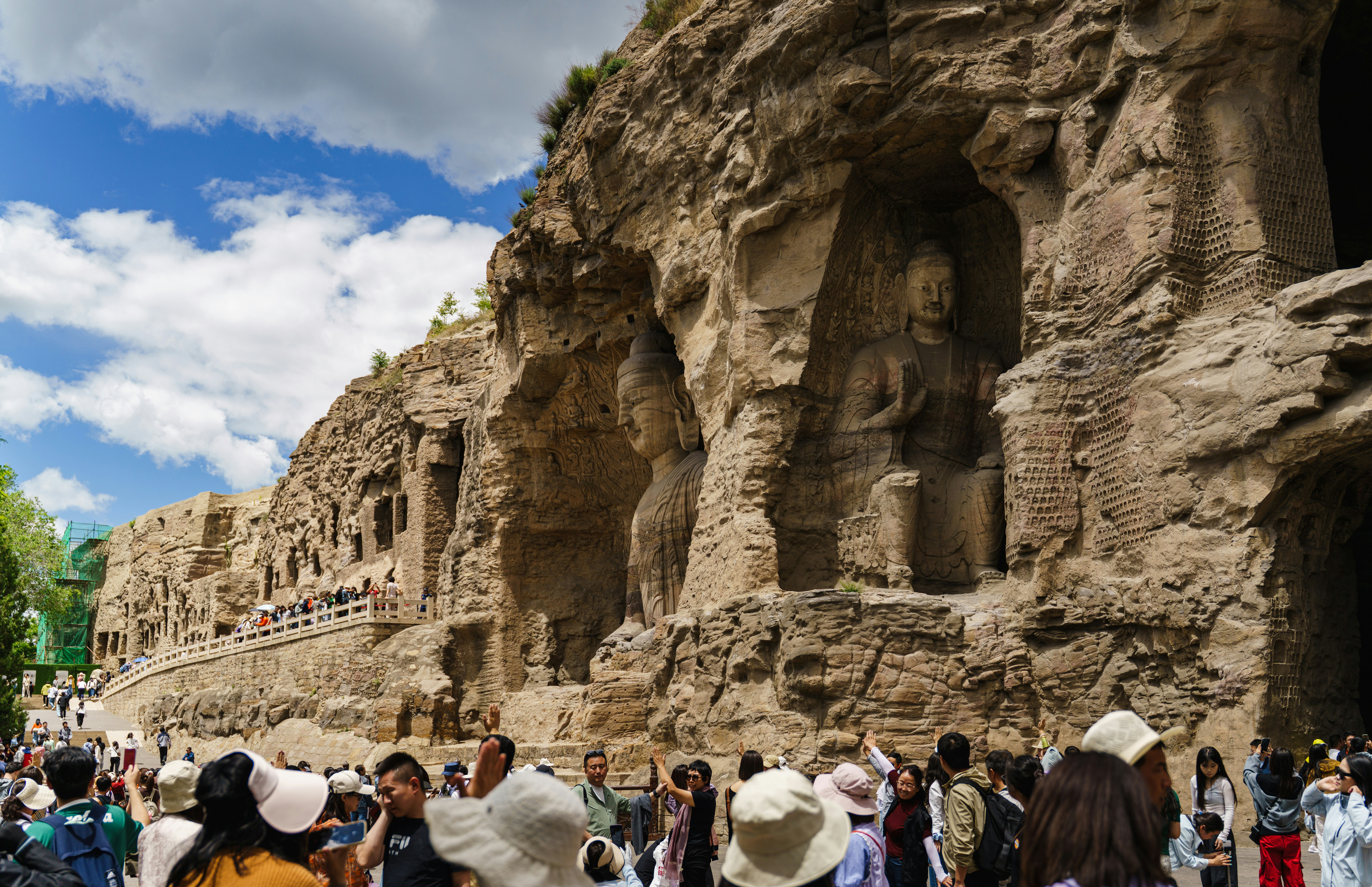Carved Giants and a Sea of Visitors at a Sacred Cliff
