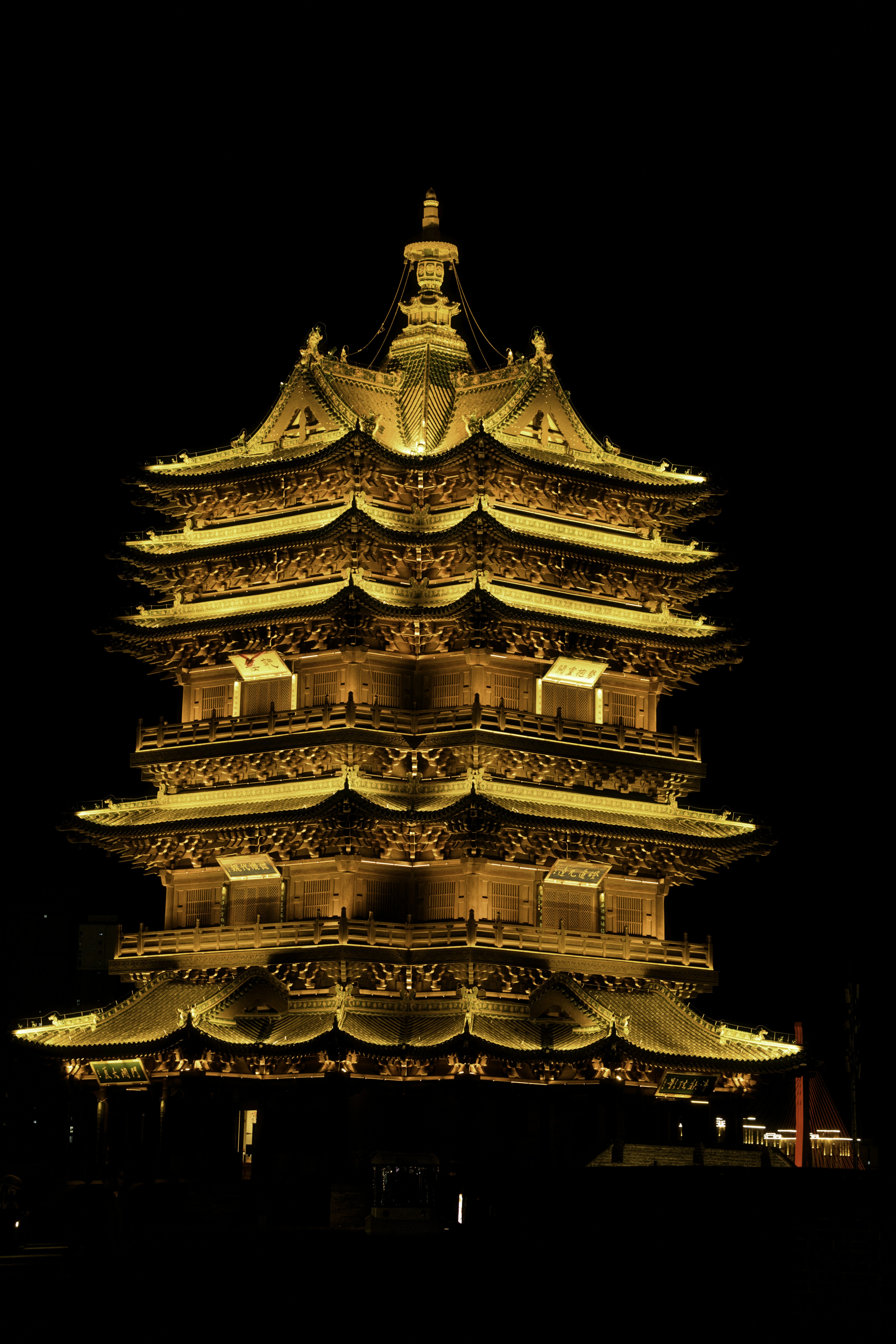 Golden Pagoda at Night: A Lanterned Tiered Tower Illuminated Against the Darkness