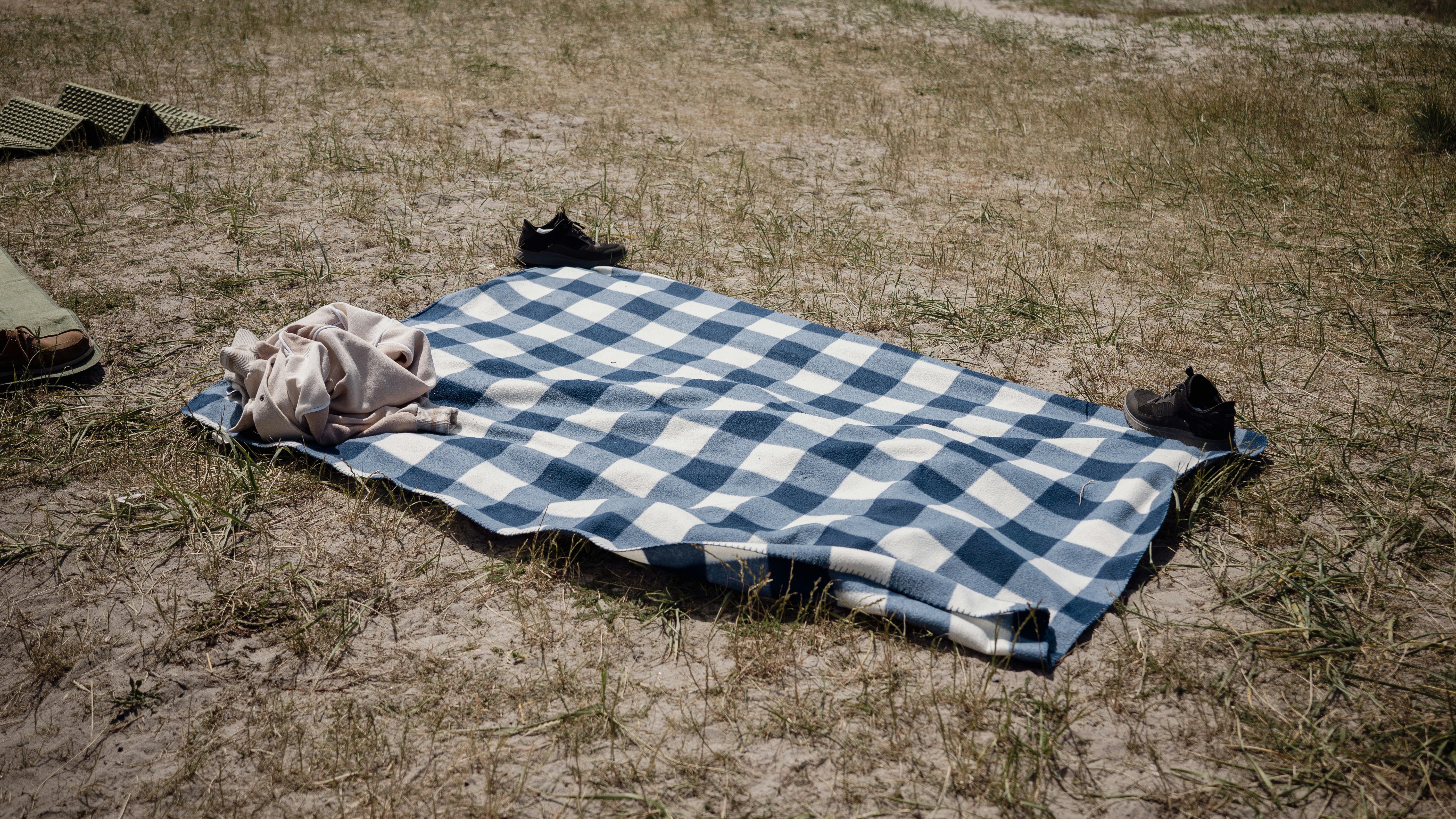 Blue-White Checkered Blanket Spreads on Dune Grass