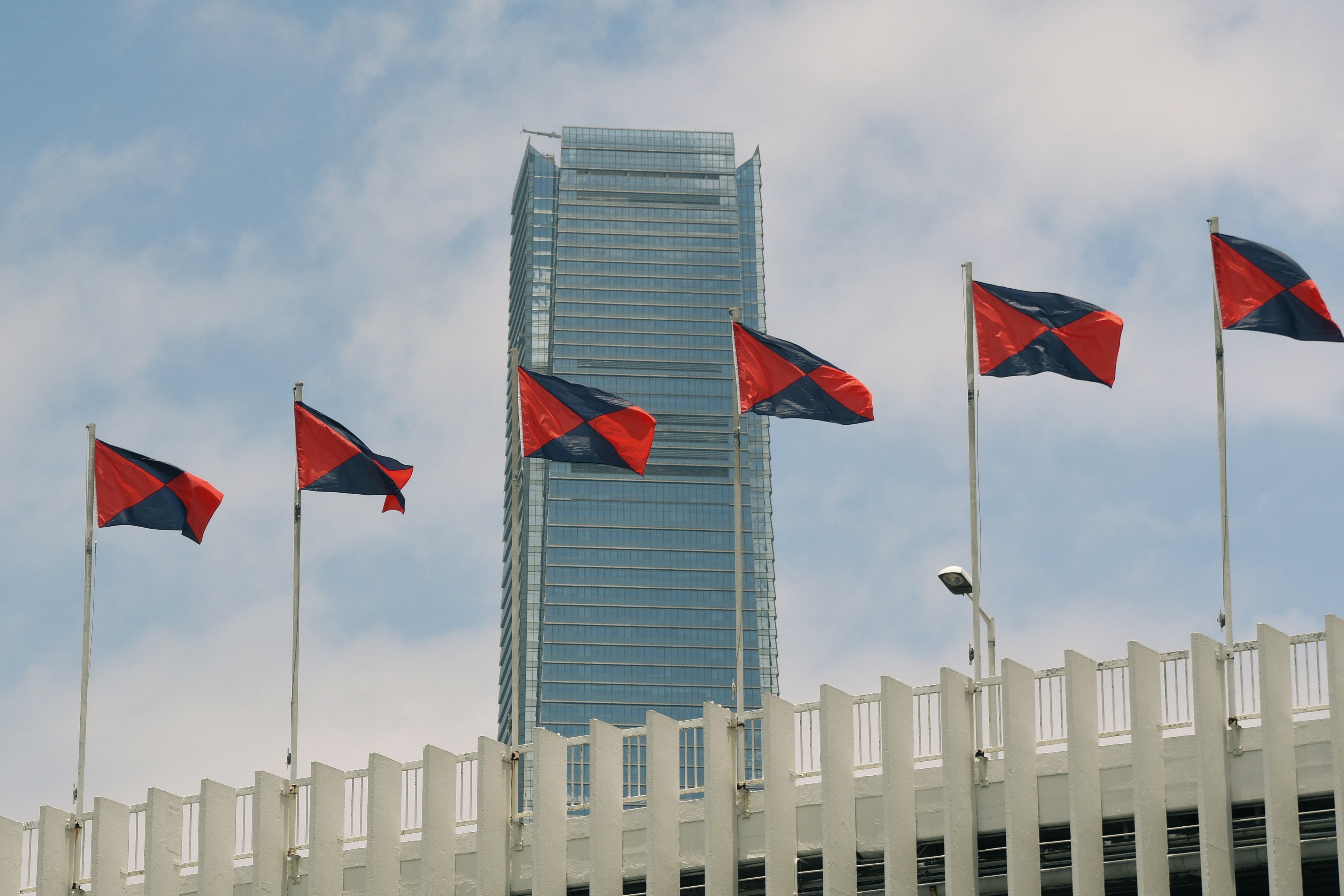 Flagged Skyline: Flags Wave Above a Modern Tower