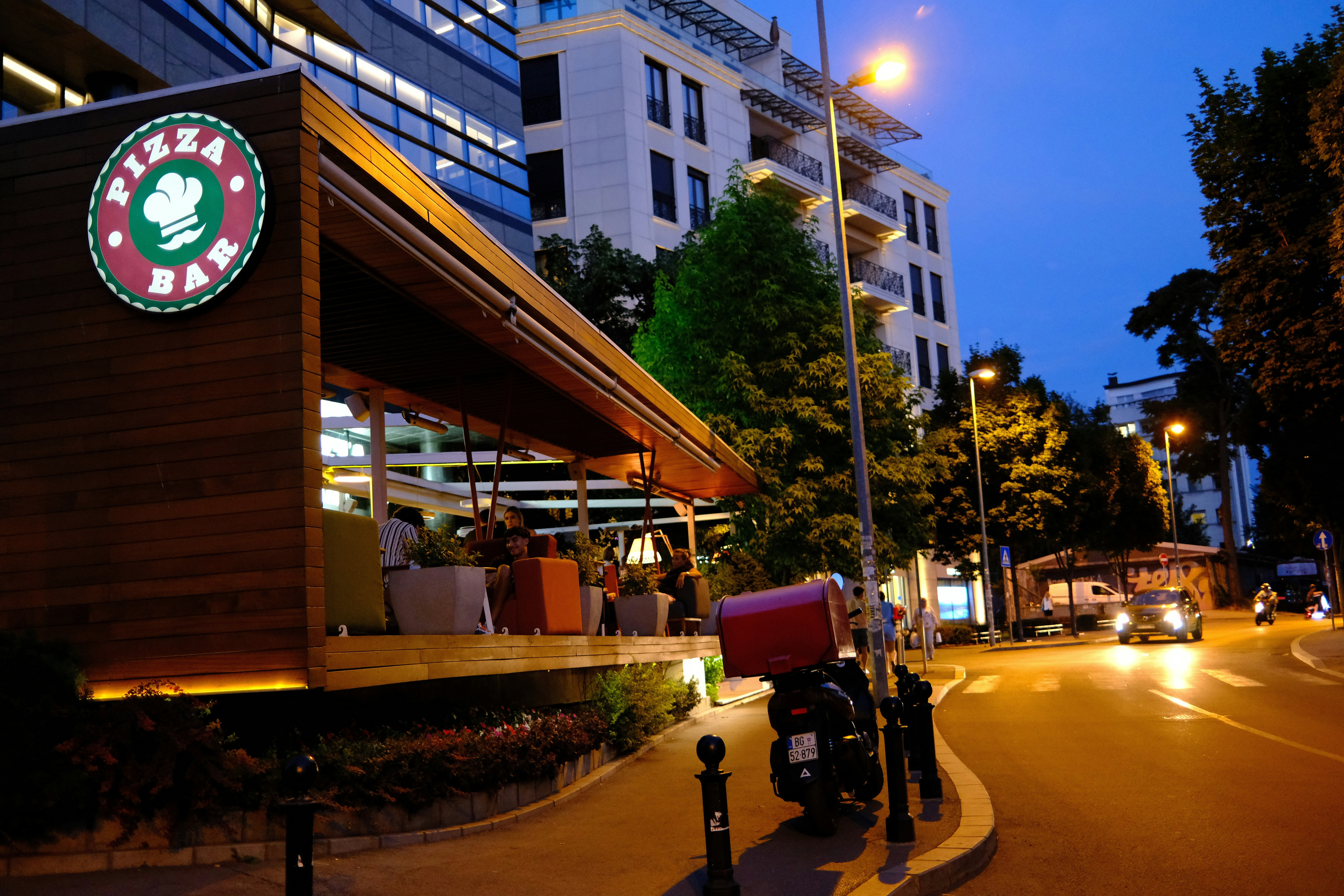 Nighttime Pizza Balcony: Warm lights and city glow