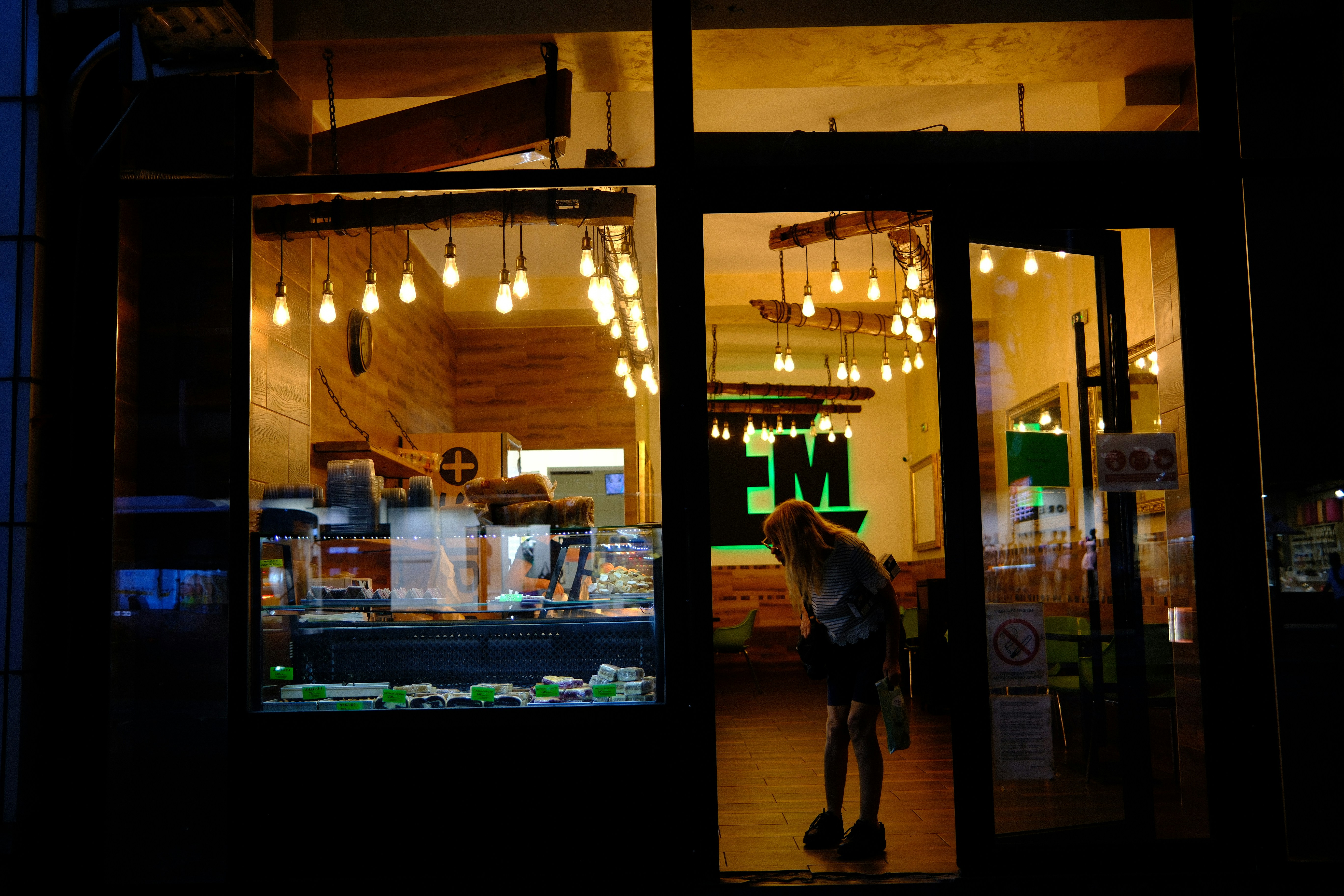 Nighttime Shopfront with Customer in Illumined Interior