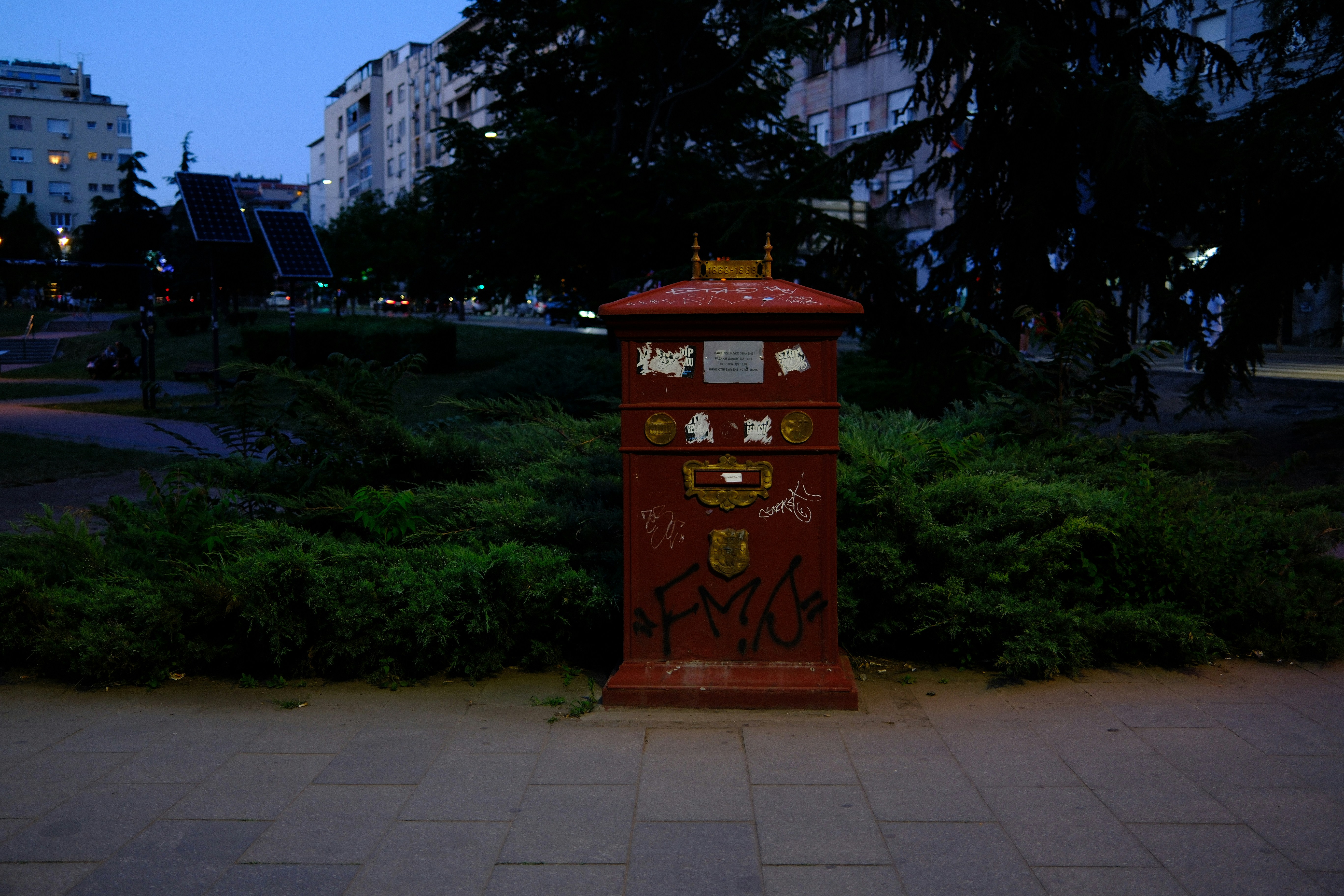 Red Mailbox in a Quiet Urban Park at Dusk