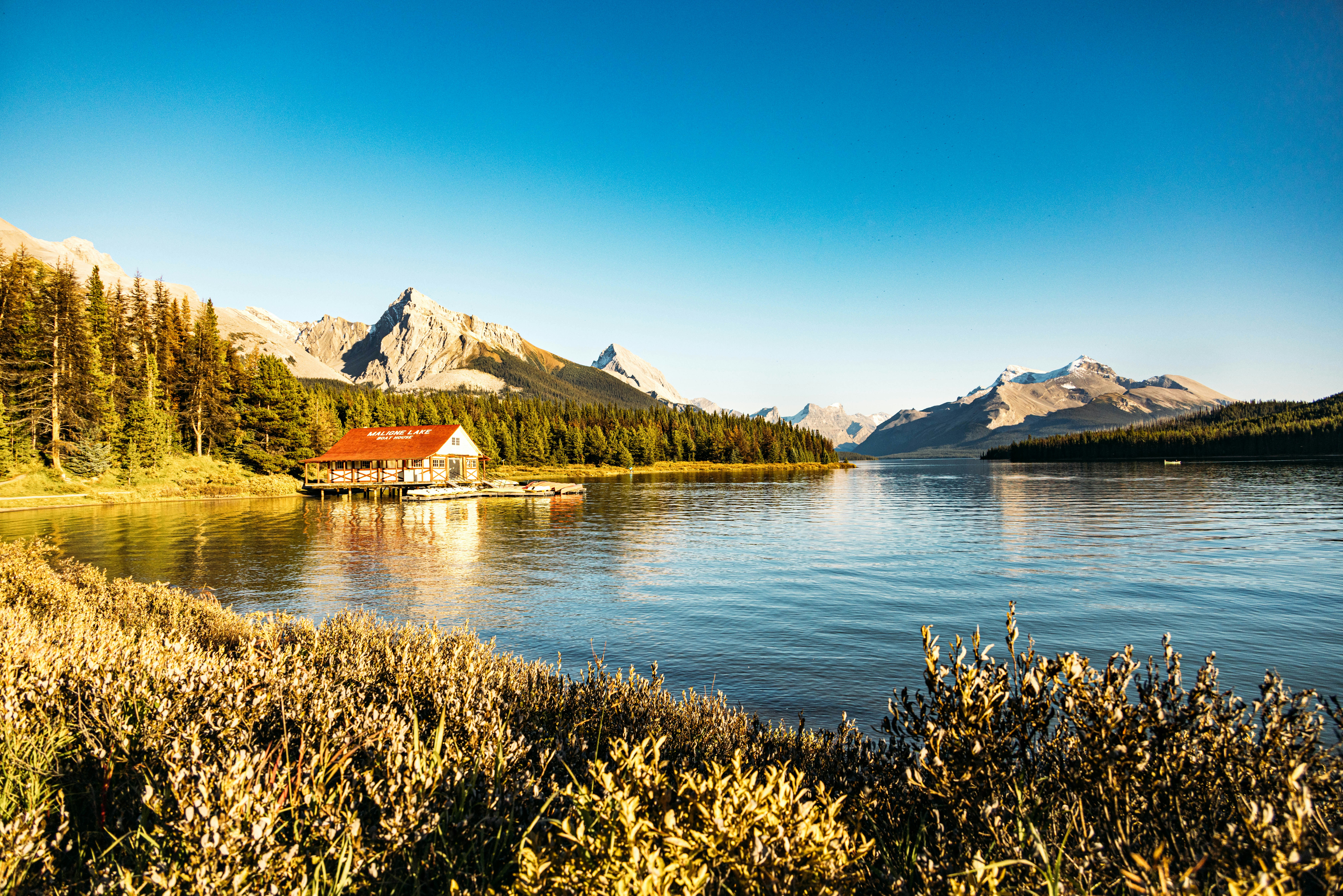 Mountain lake with a boathouse and surrounding forest.
