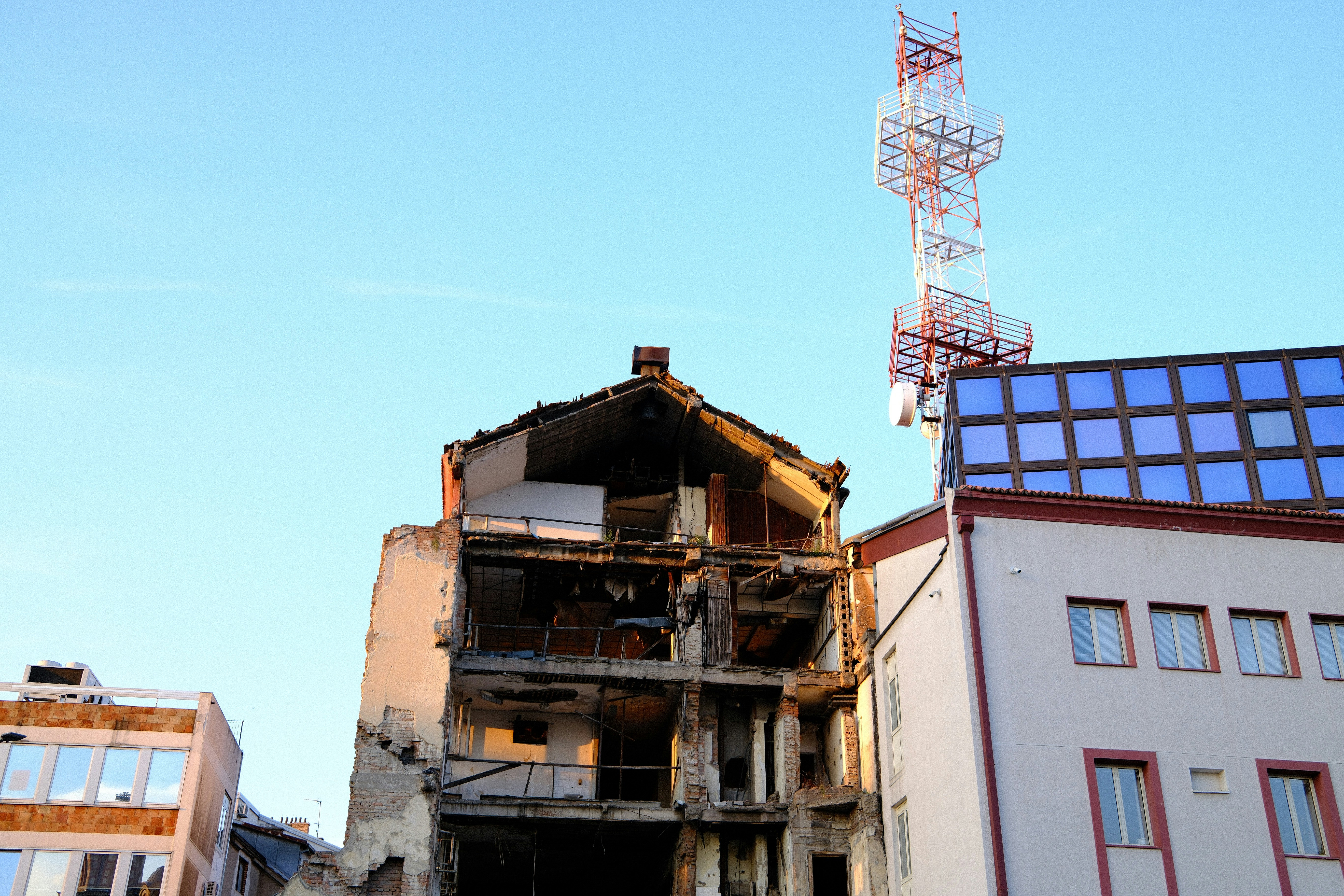 Ruined Skyline: A Weathered Building Next to Modern Infrastructure