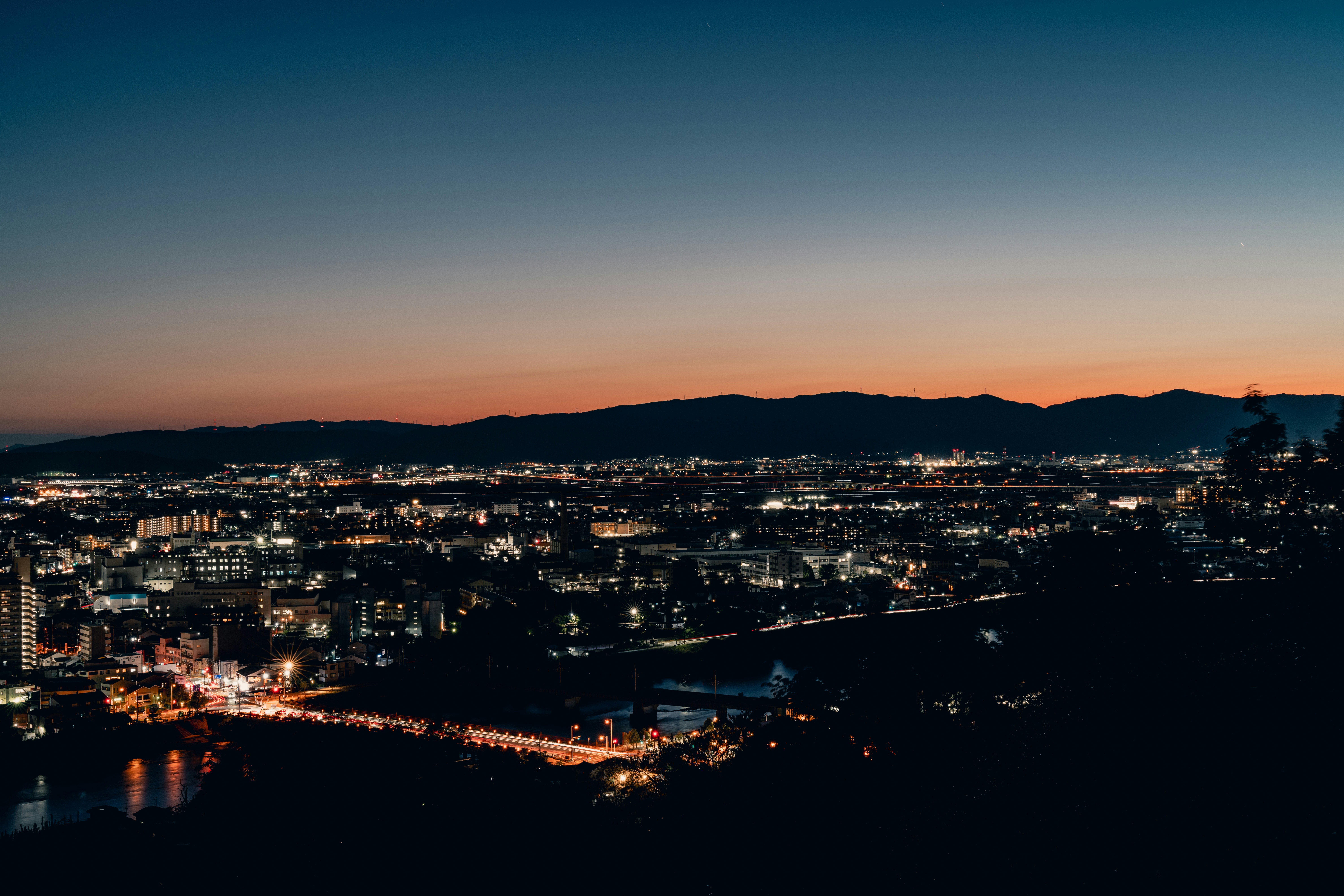 Twilight cityscape over a quiet river bend