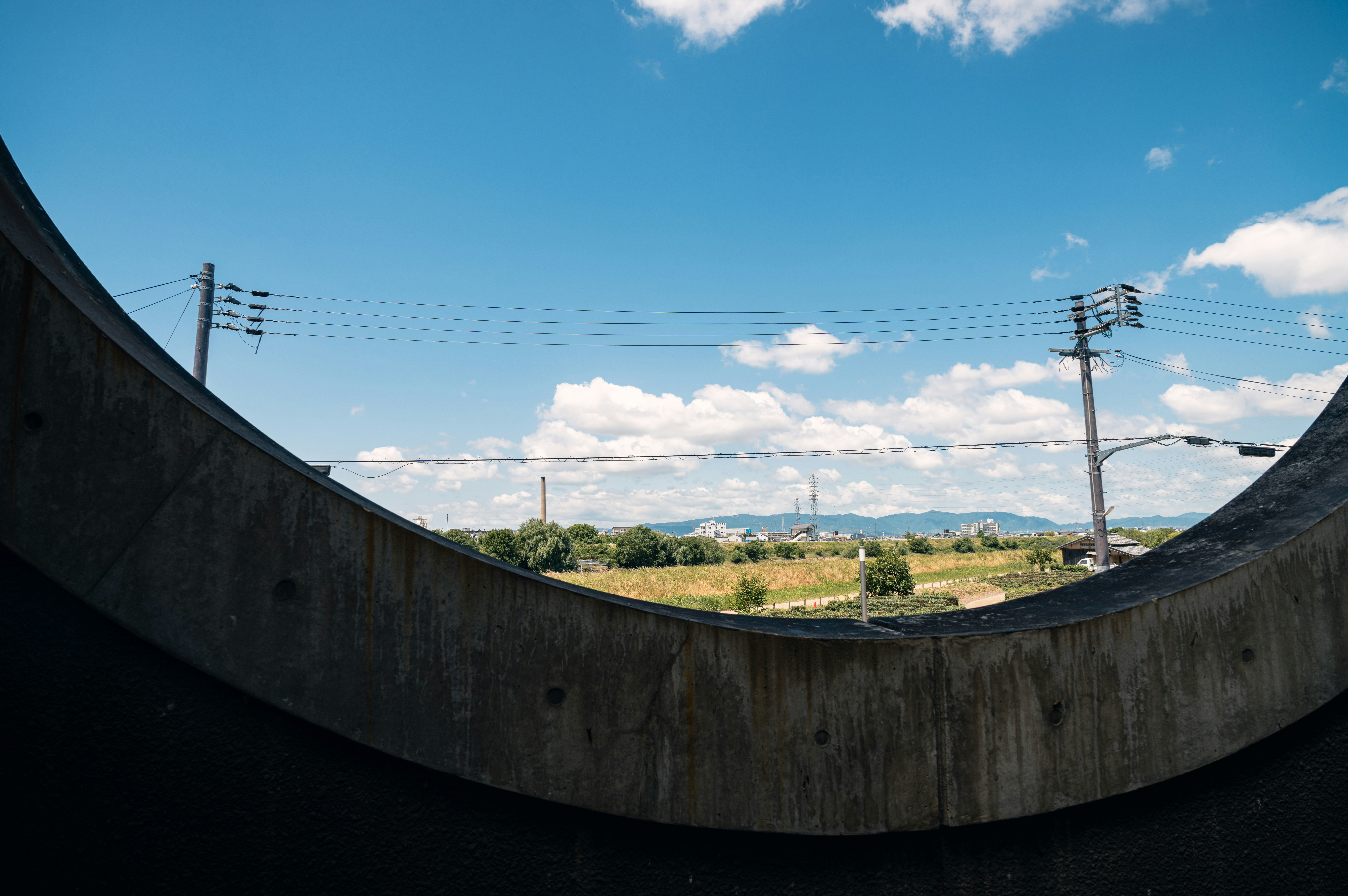 Through the Circular Lens: Suburban Horizon Framed by Concrete Curve