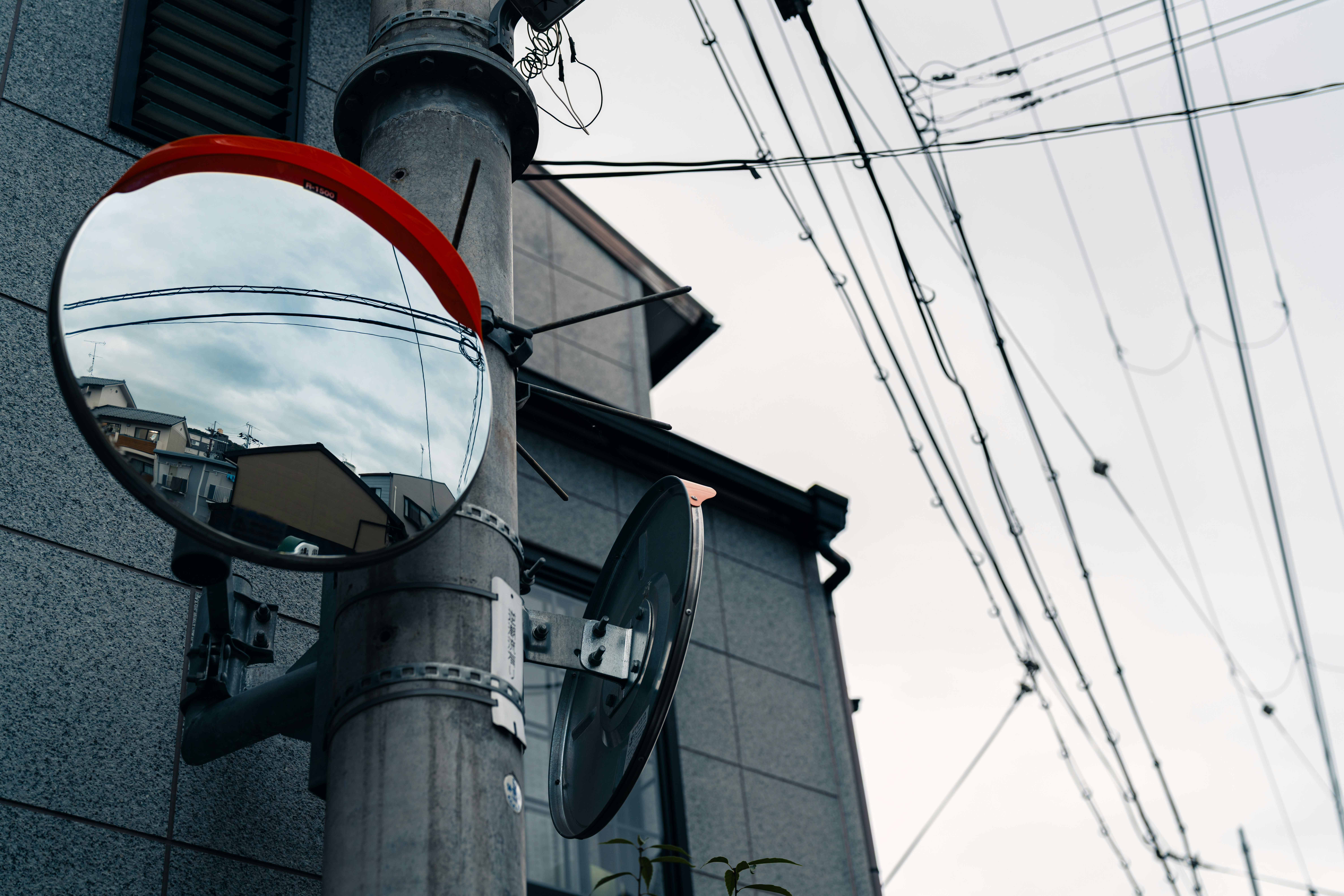 Mirror on the Utility Mast: Reflections Across a Quiet City Facade
