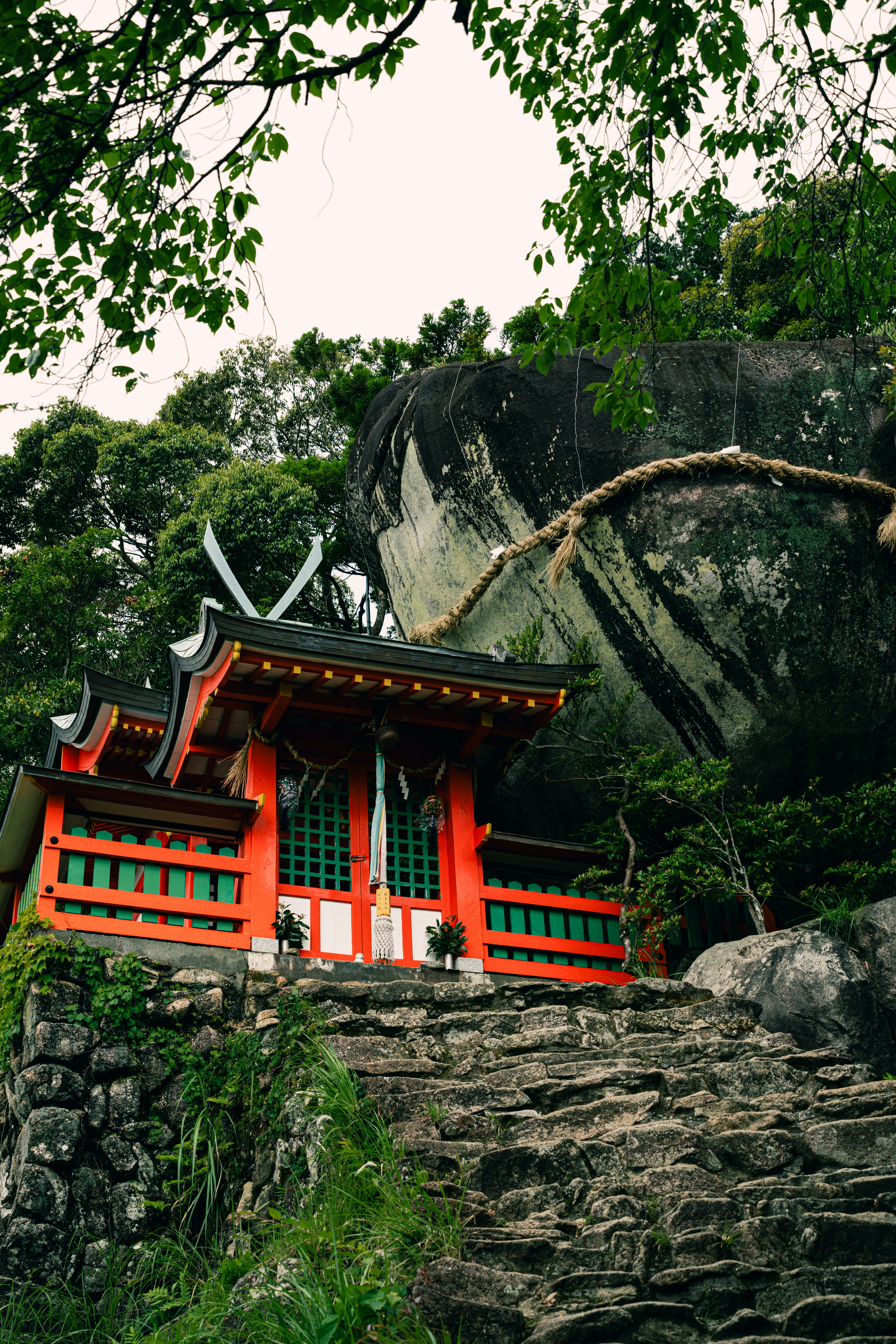 Vibrant Shrine at the Foot of a Weathered Monolith