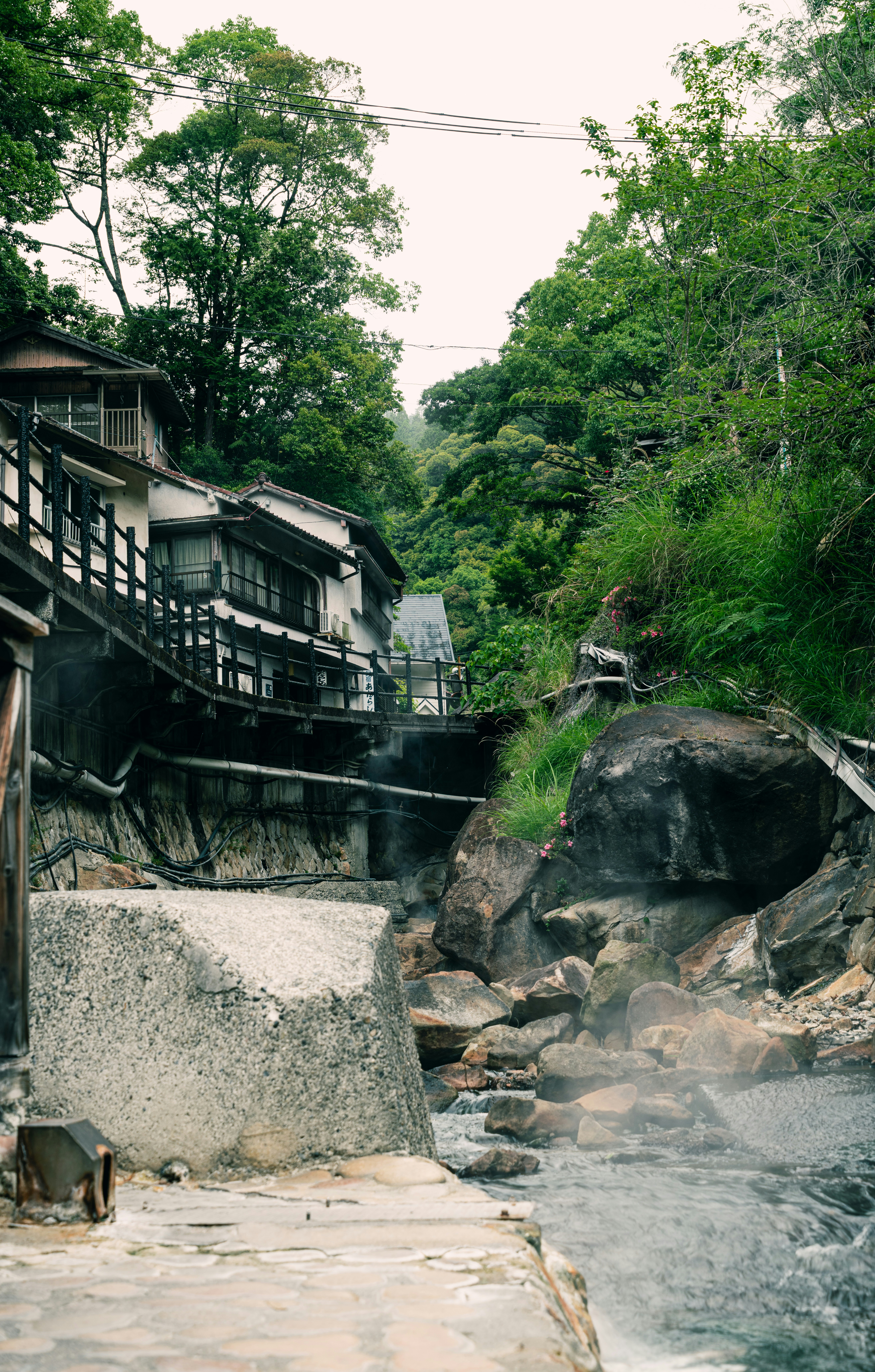Rugged riverside street tucked among mossy rocks and wooden houses