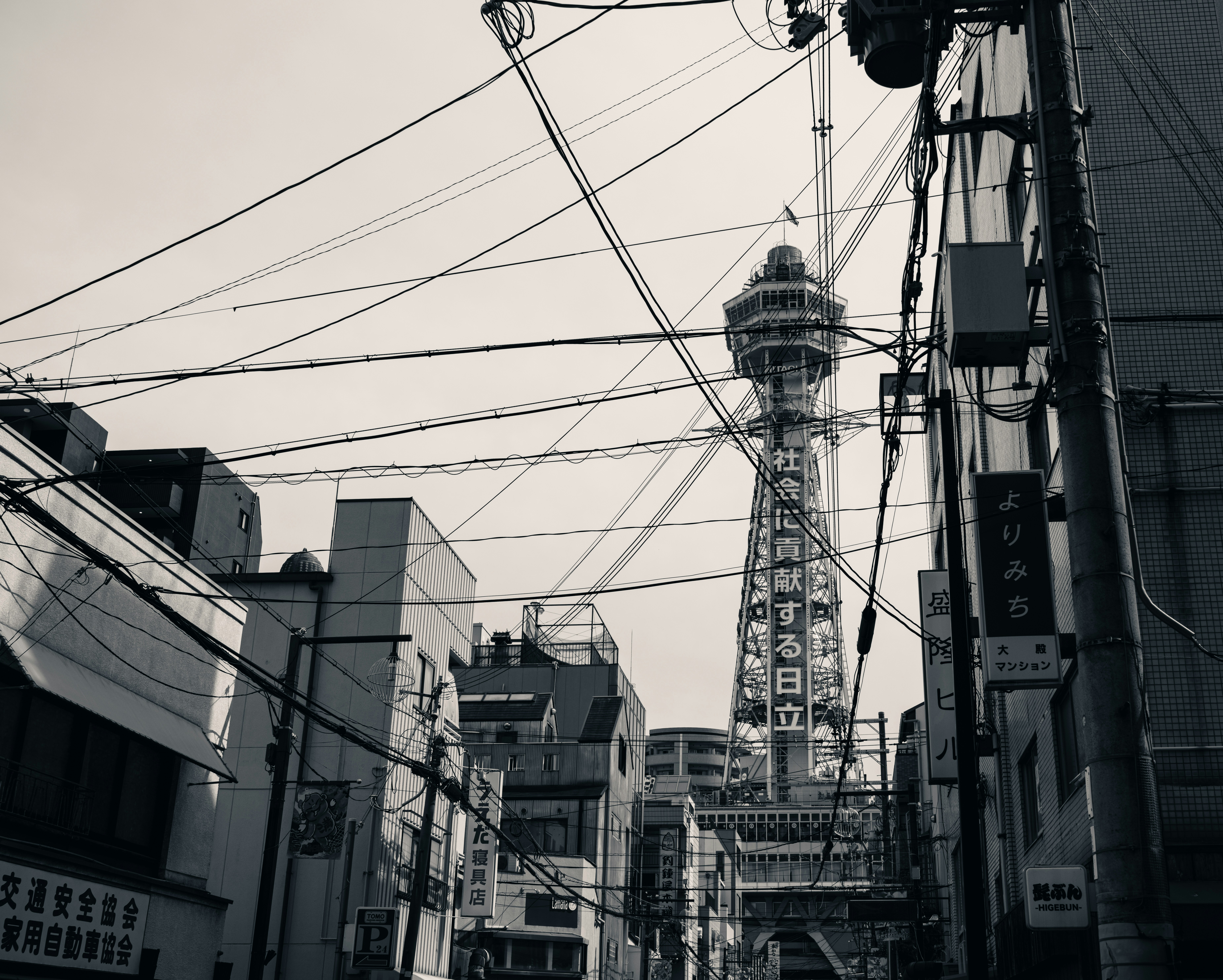 Rooftops and Wires: A Narrow Street Converges on a Tower