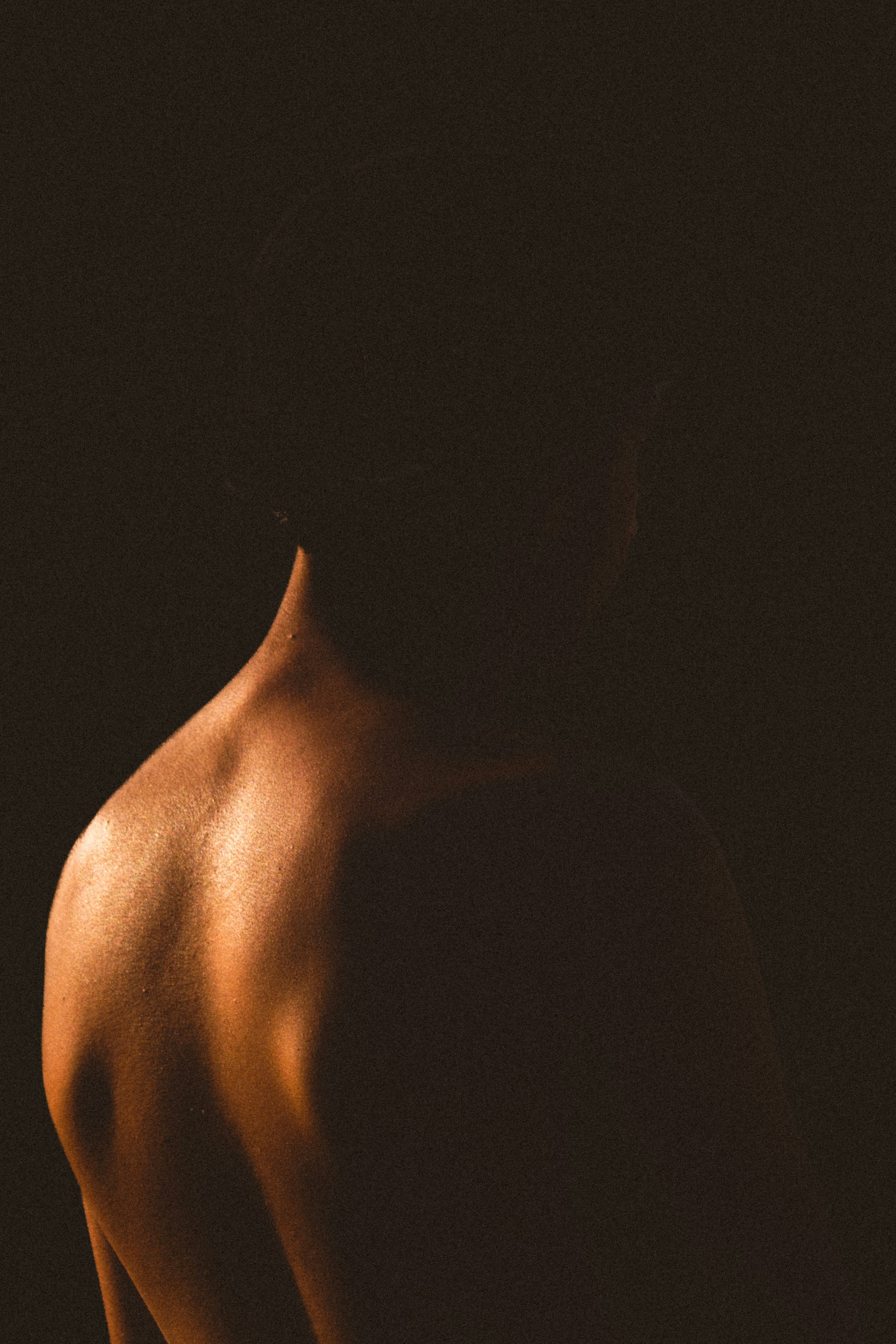 Silhouette of Bare Shoulder: Warm Light on the Back