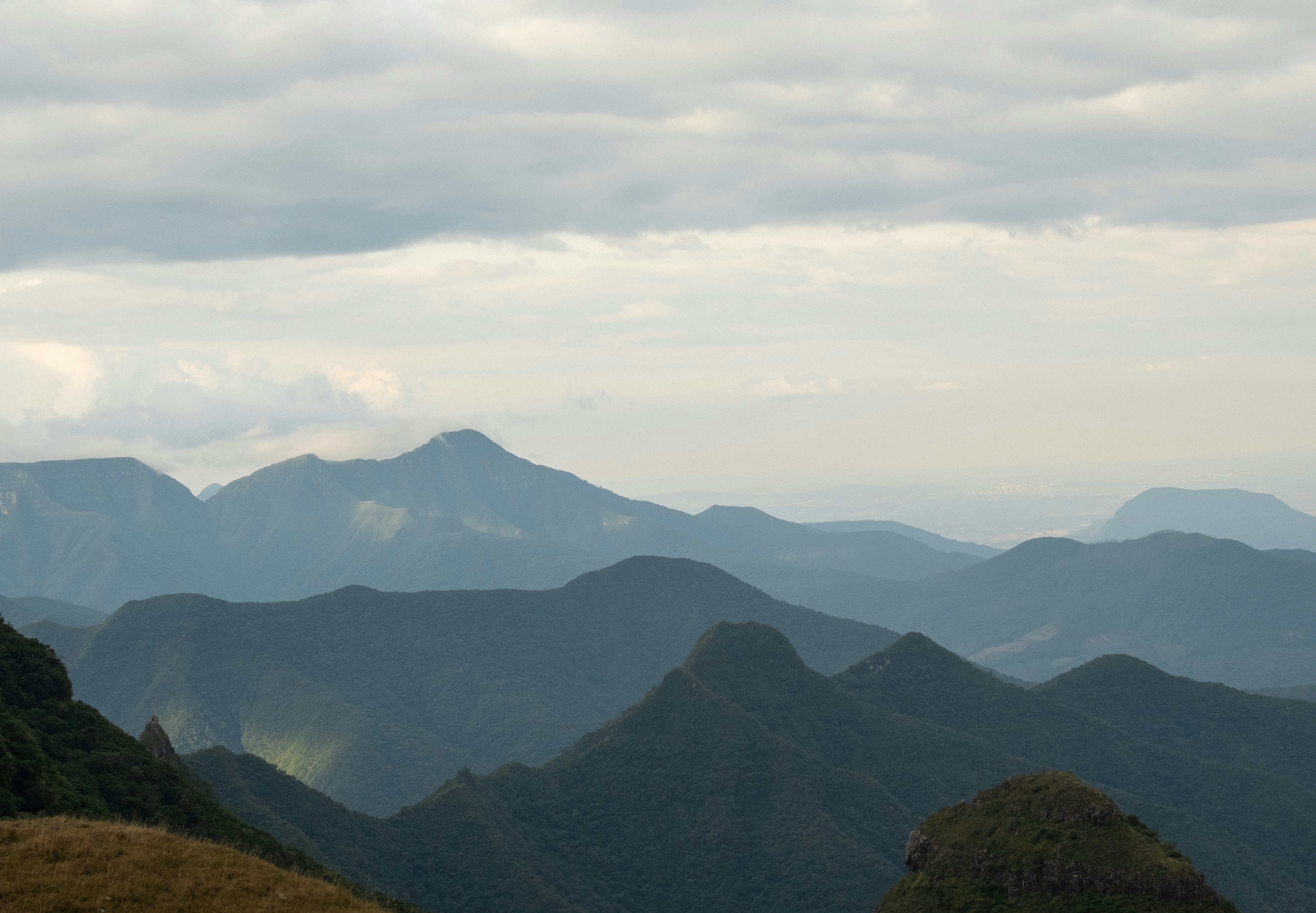 Layers of misty mountains under a cloudy sky.