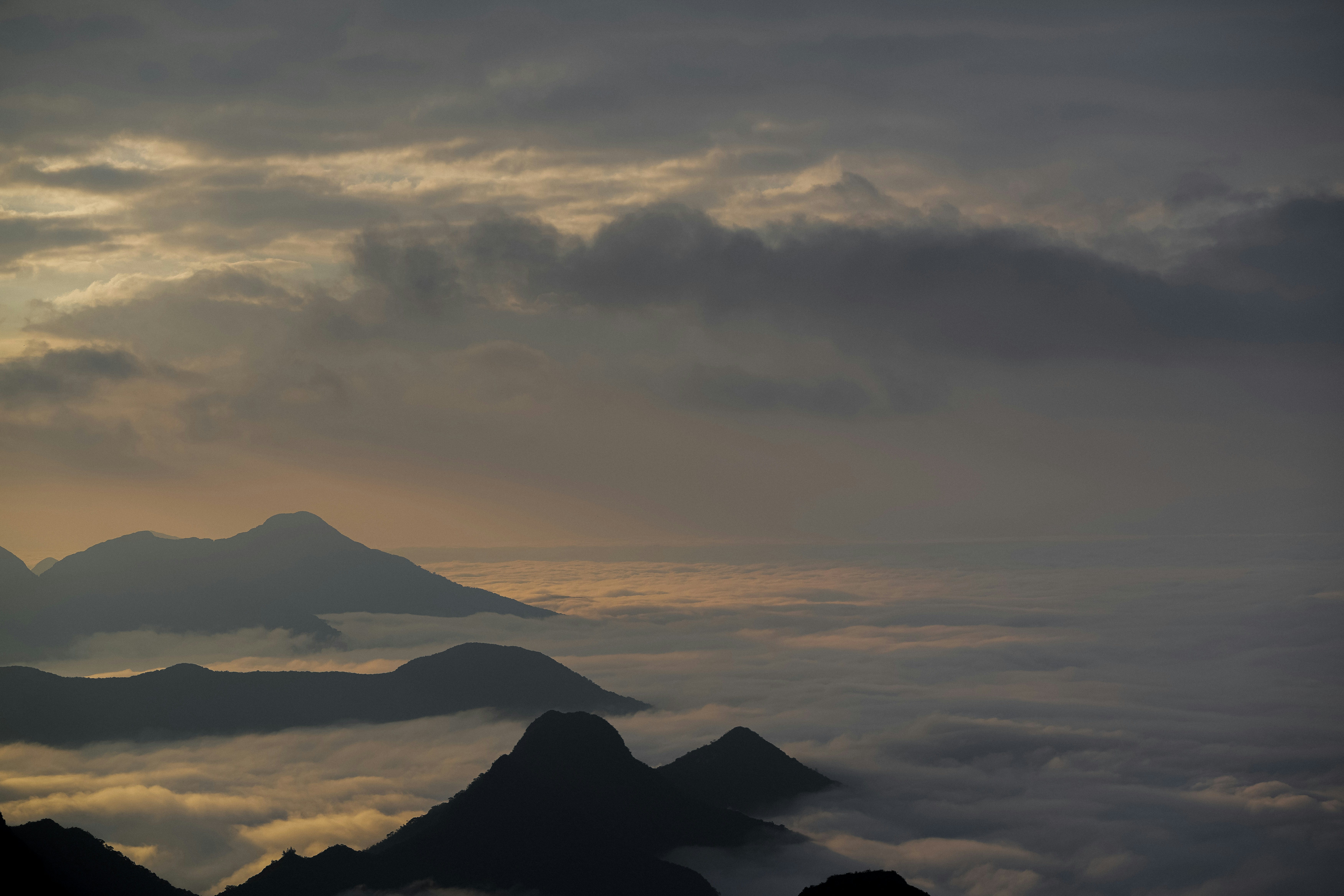 Mist-veiled Peaks at Dawn over a Quiet Sea