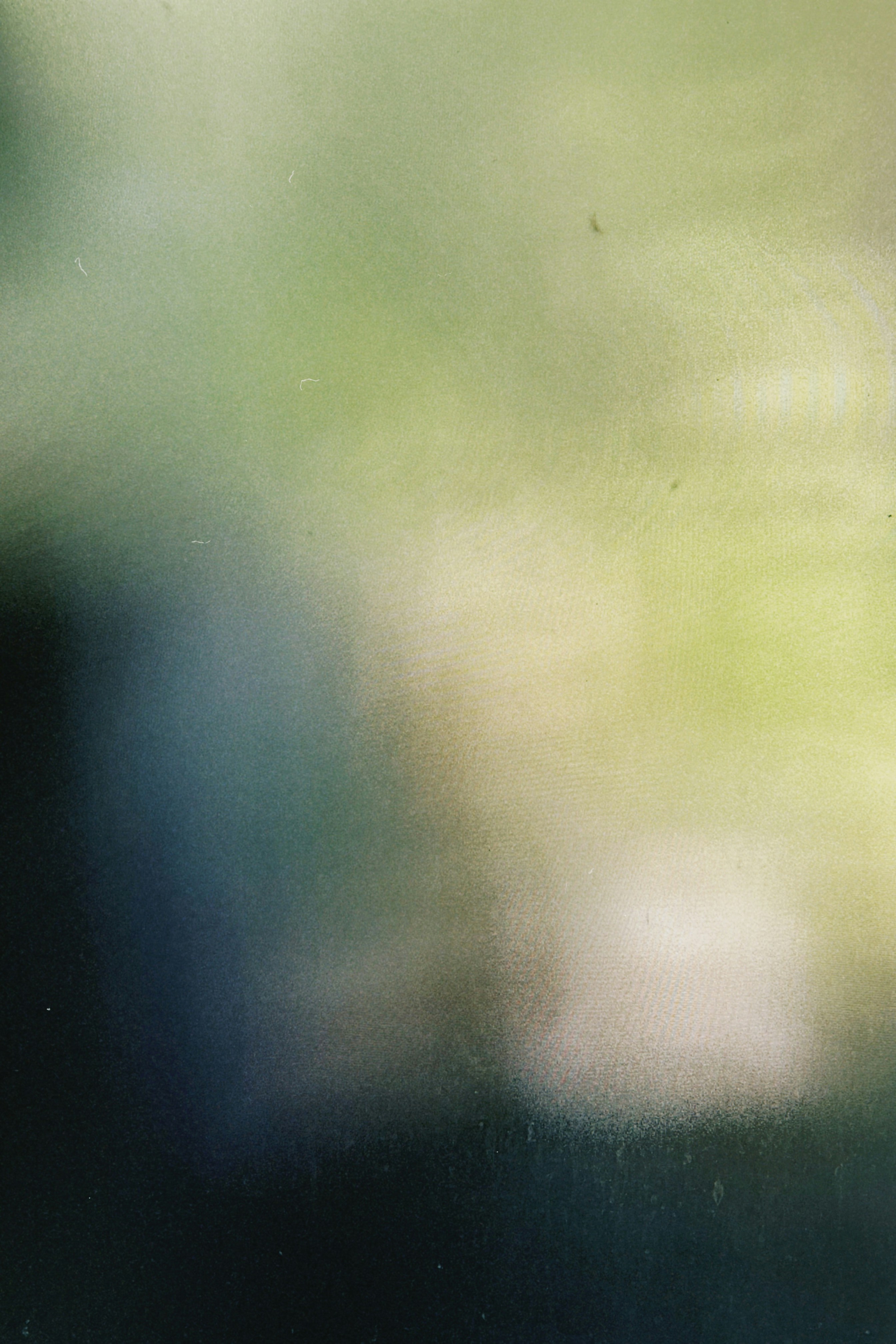 Abstract blur of green, yellow, and dark colors.