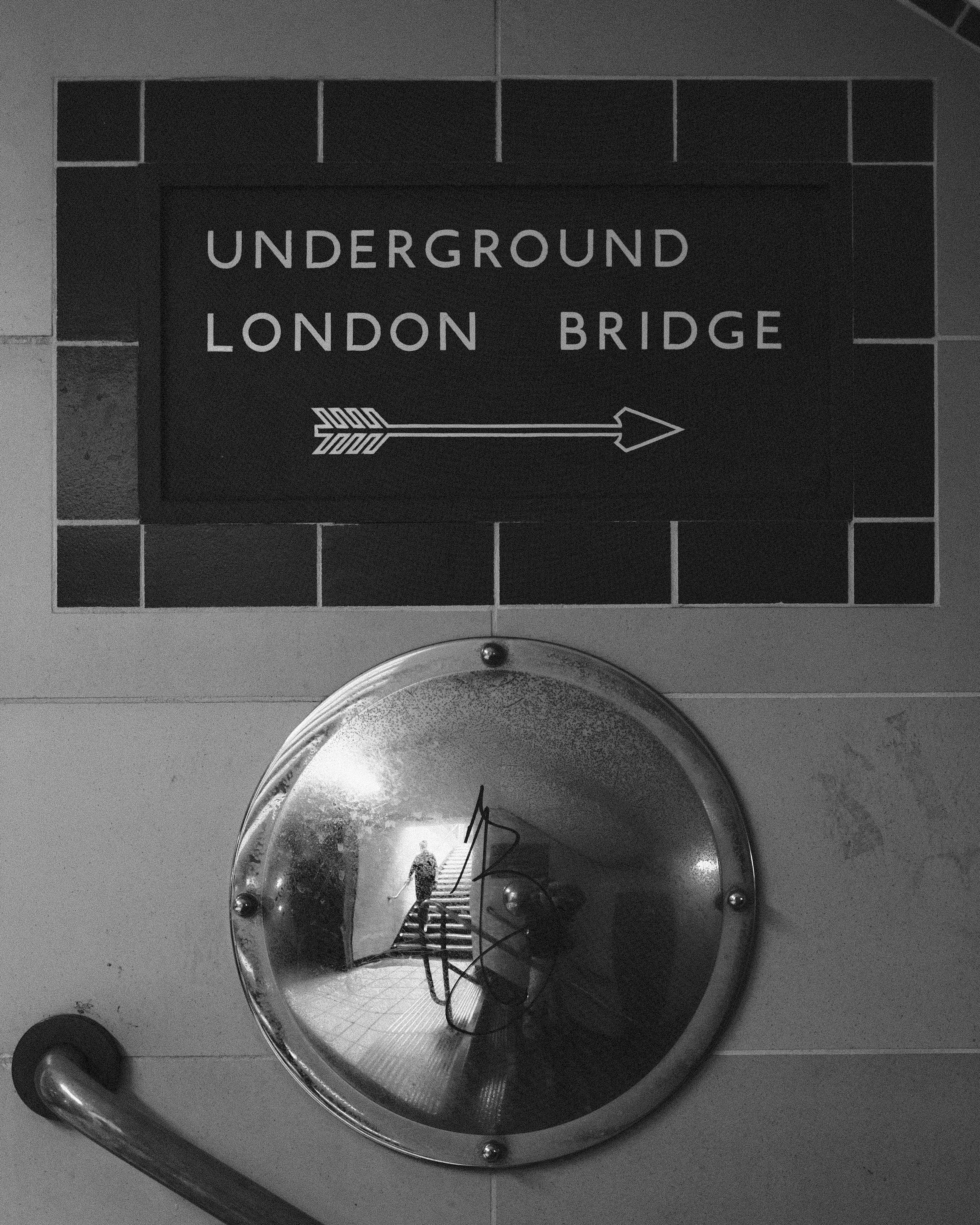 Round Mirror, Tunnel of Reflections: London Underground Sign Above a Gleaming Station Mirror