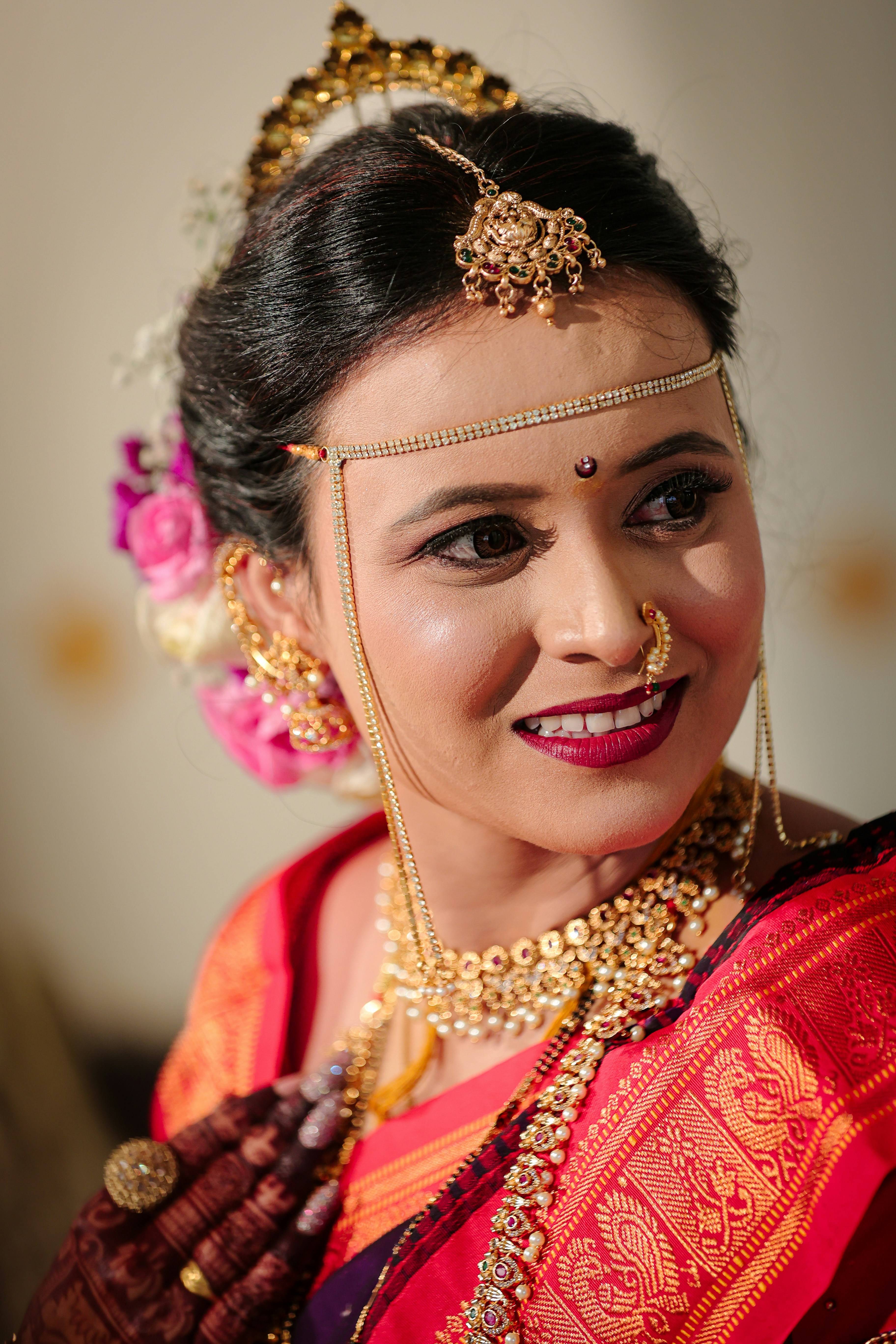 A beautiful indian woman in traditional attire and gold jewelry.