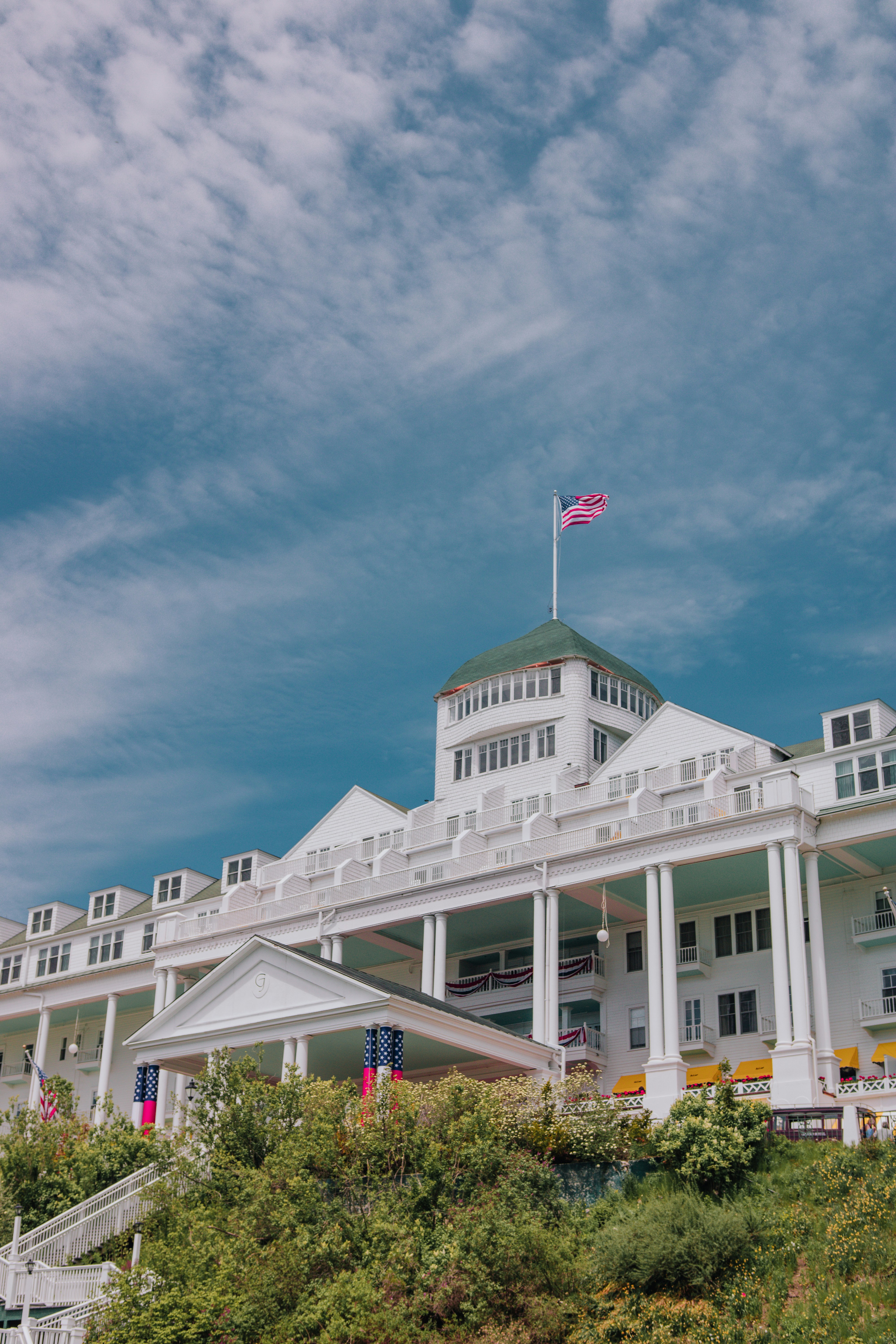 Flag over a seaside resort: sunlit white facade and green-roofed pavilion