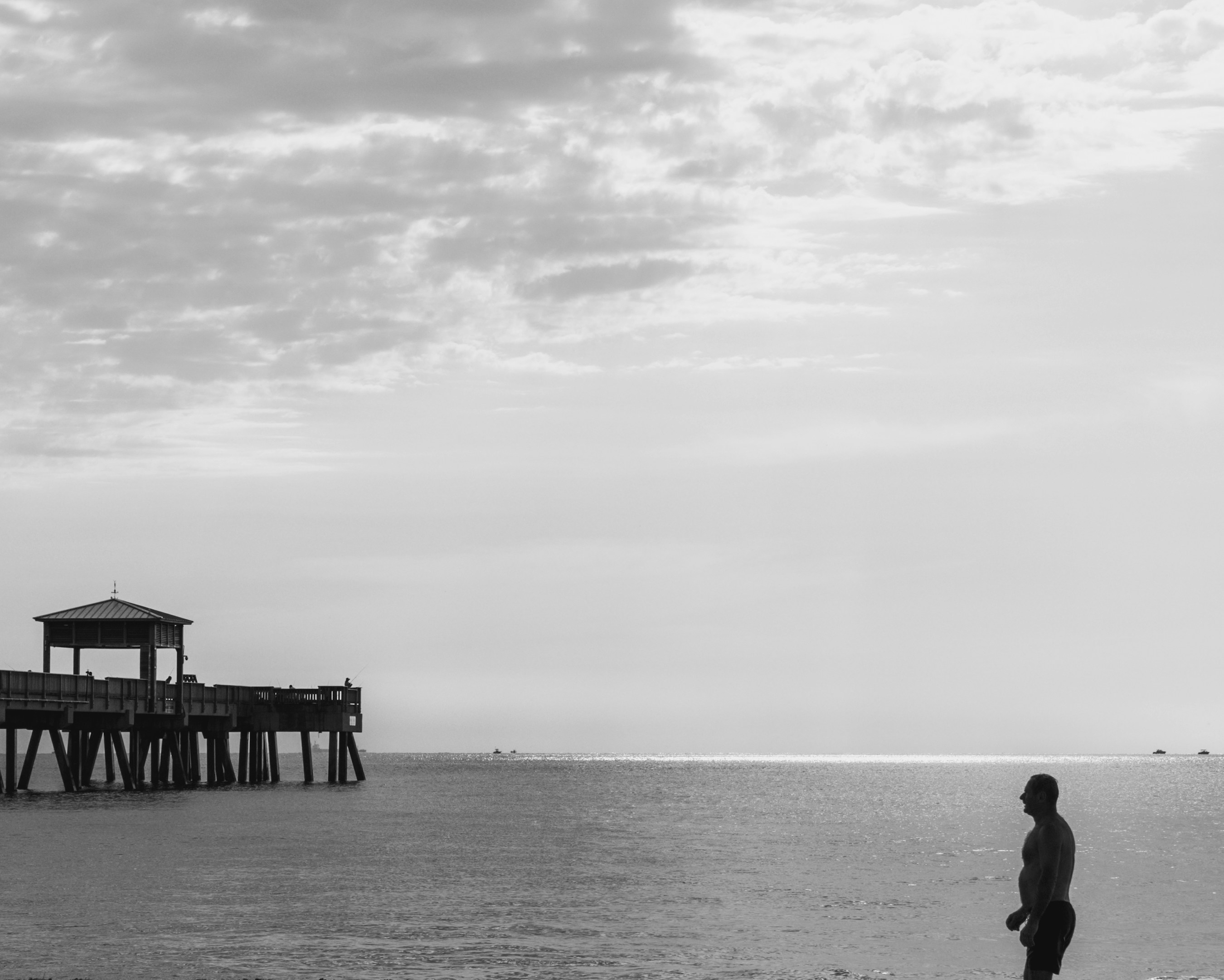 Quiet Horizon: A lone figure at the end of the pier