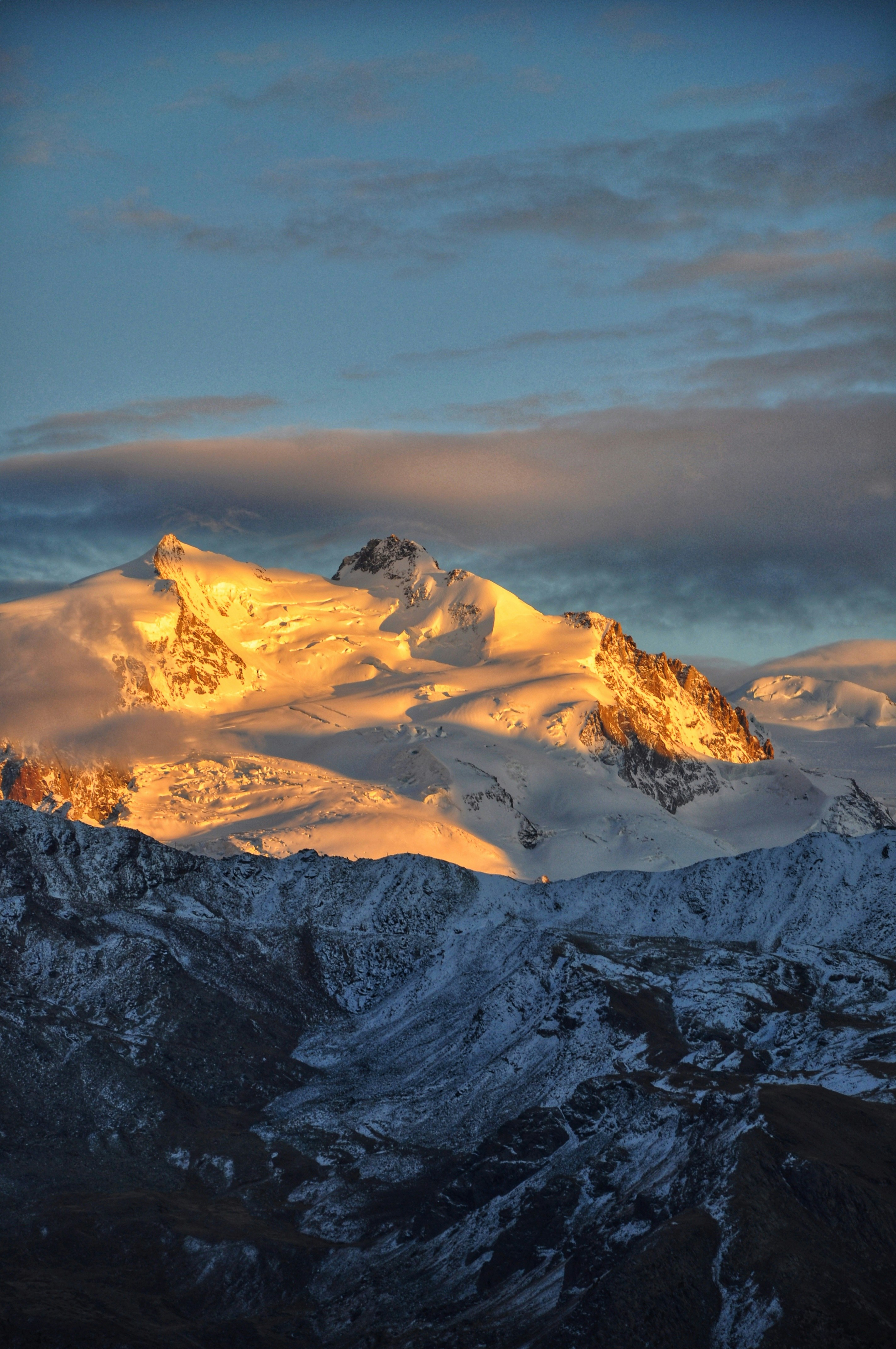 Golden Peaks at Dawn: A Snow-Capped Sunrise over Rugged Ranges
