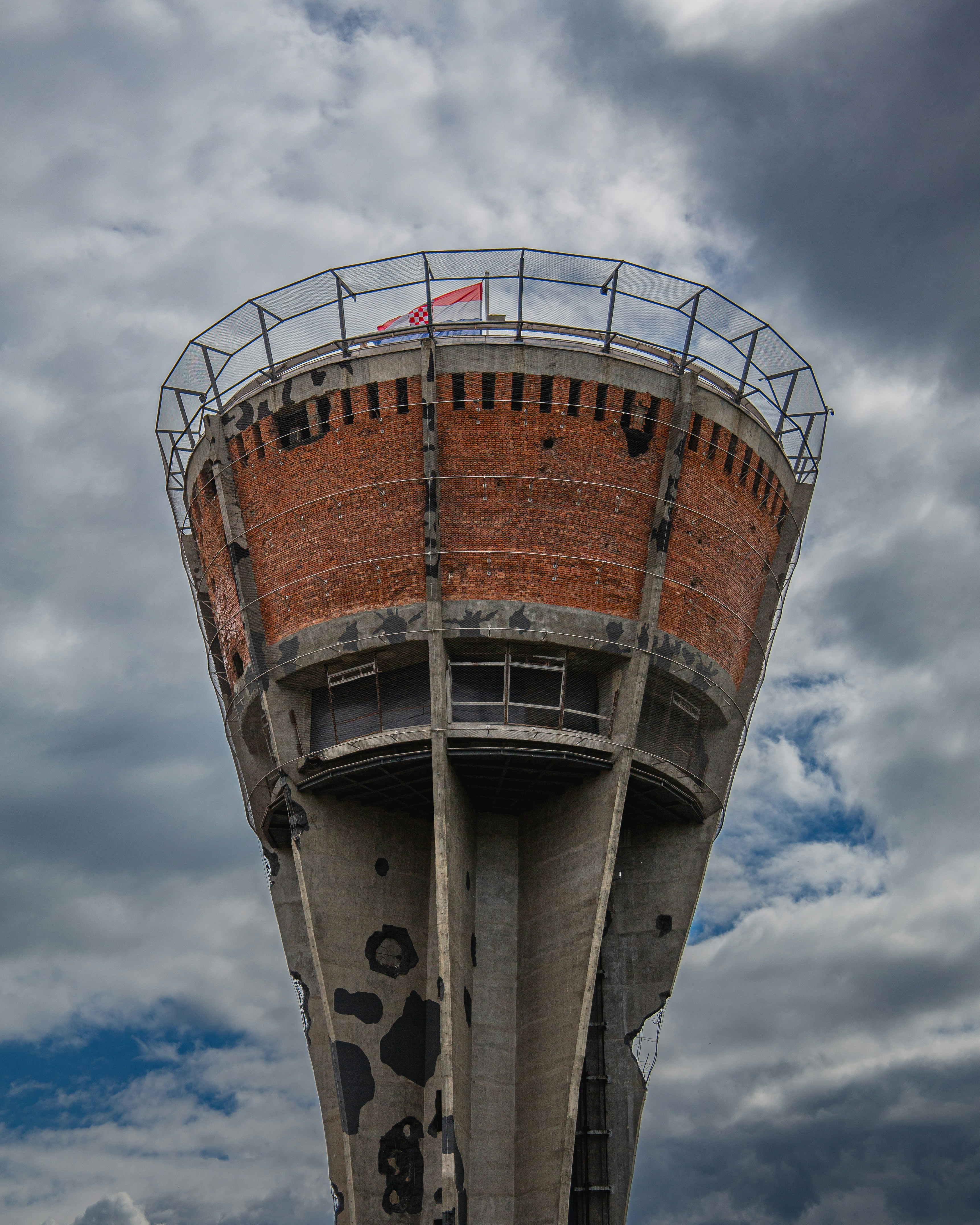 Rugged Water Tower Reaches Skyward Against Turbulent Clouds