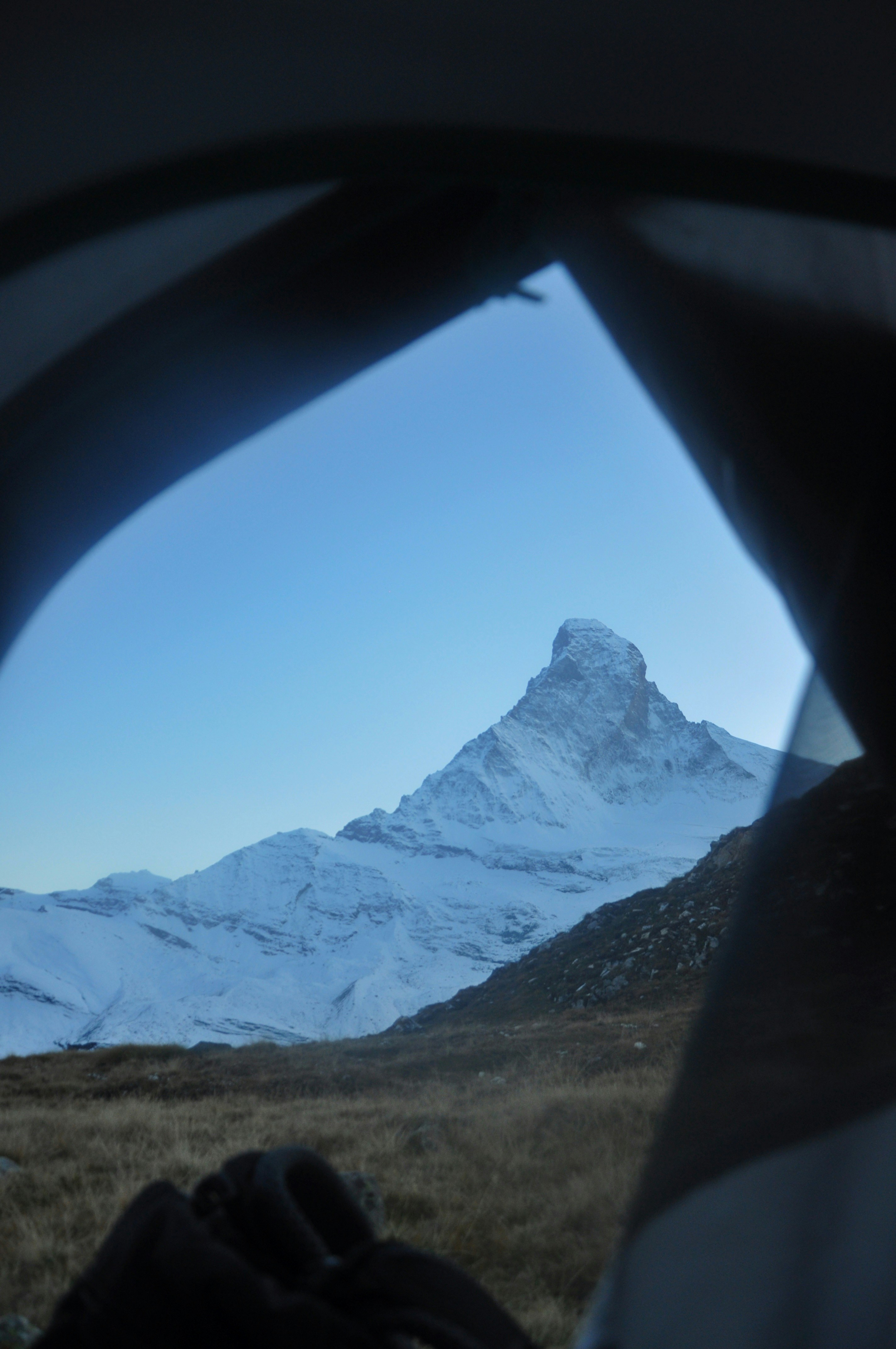 Through a Tent Opening: A Snow-Capped Peak Framed by Fabric and Shadow