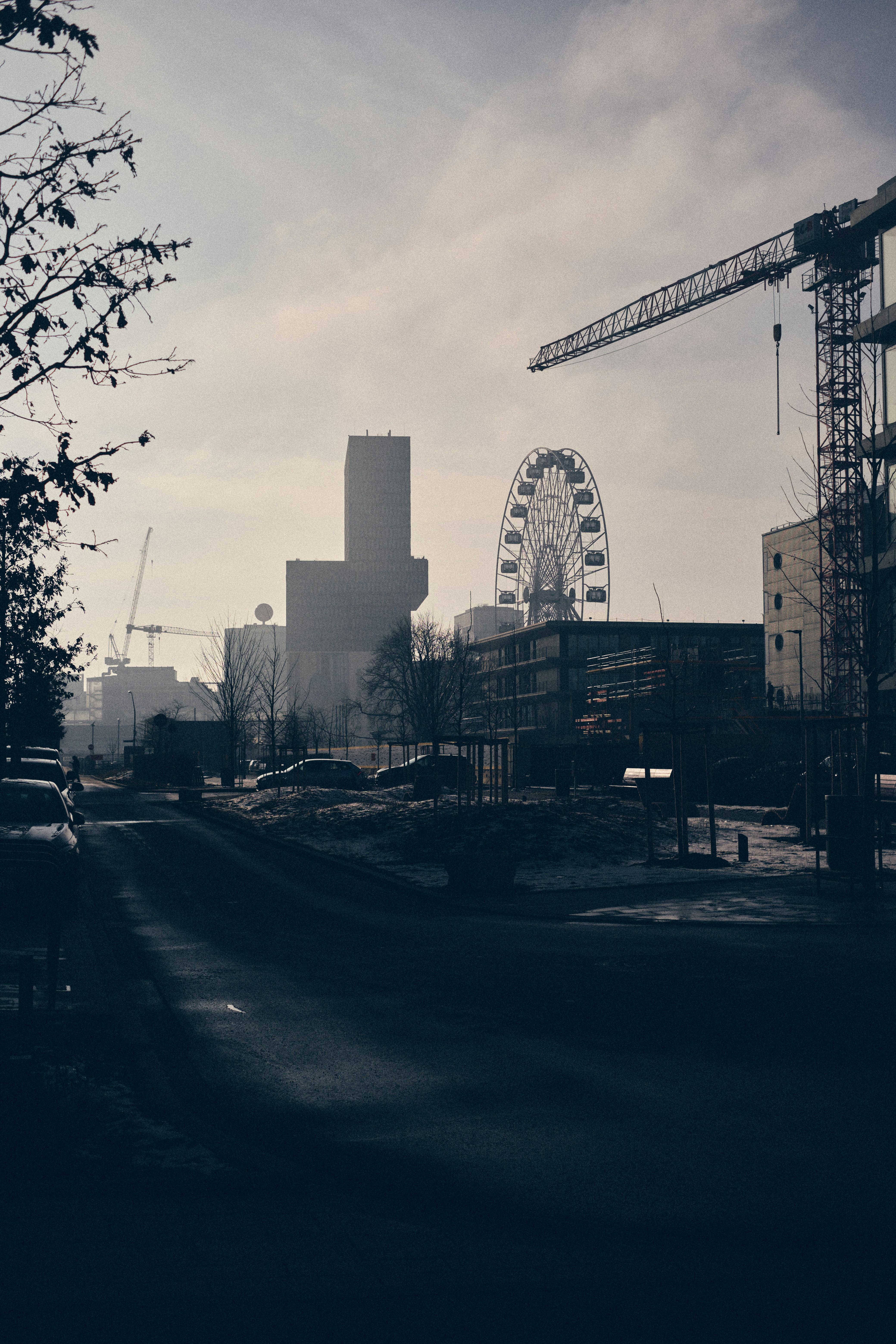 Urban Construction Horizon: Ferris Wheel Silhouette at Dusk