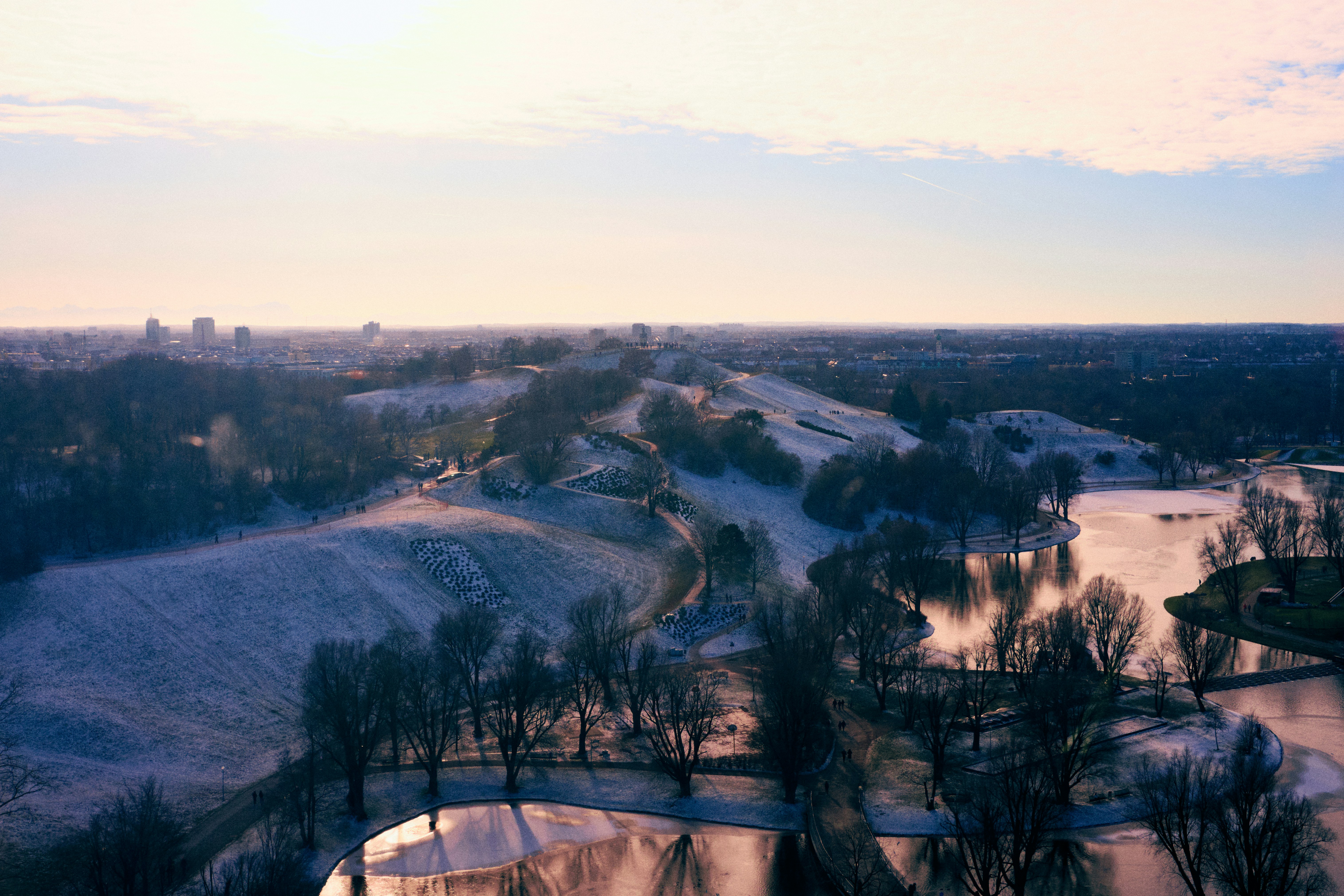 Snow-kissed parkland under a pale winter sunset