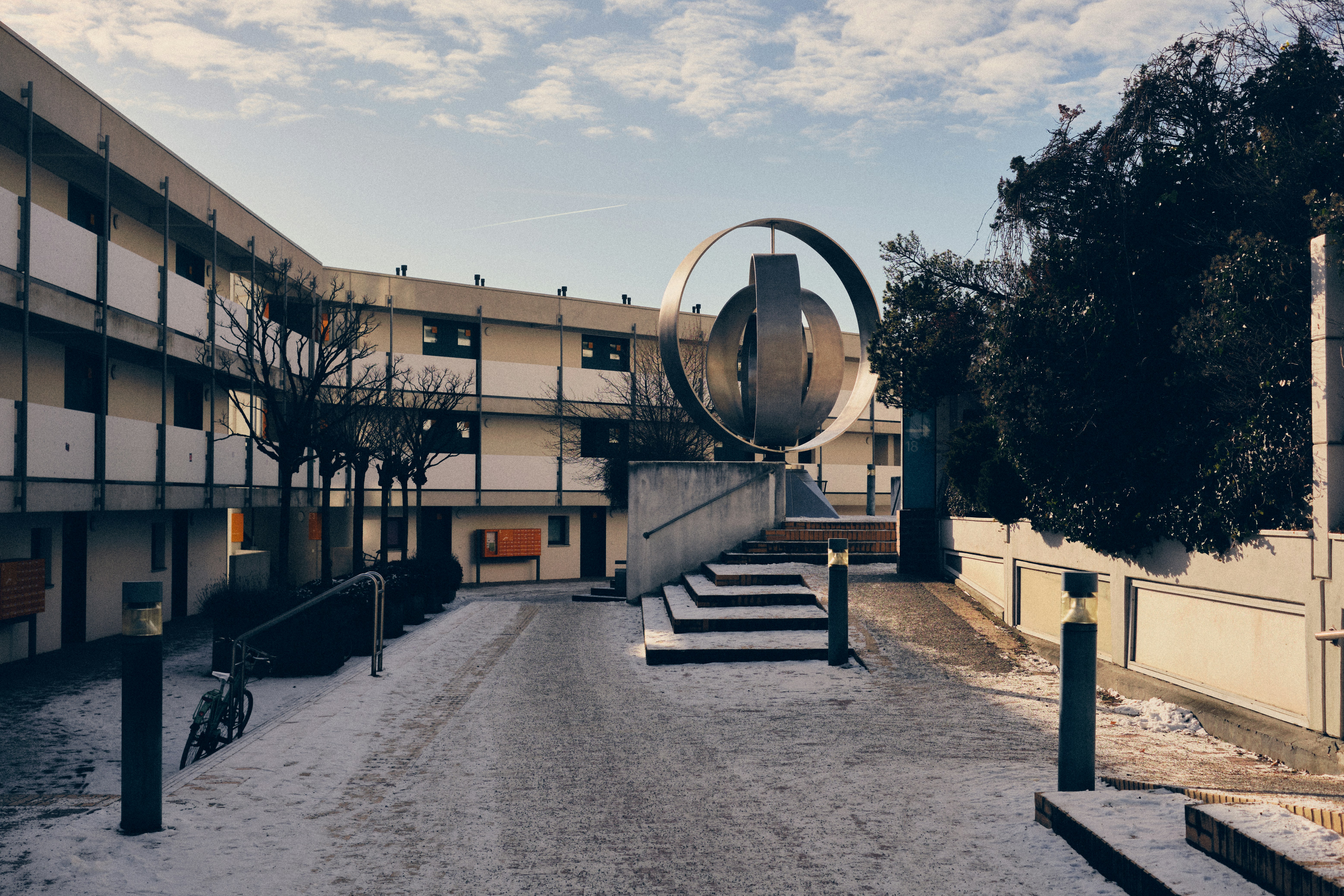 Circular monument over stepped plaza at an empty campus courtyard