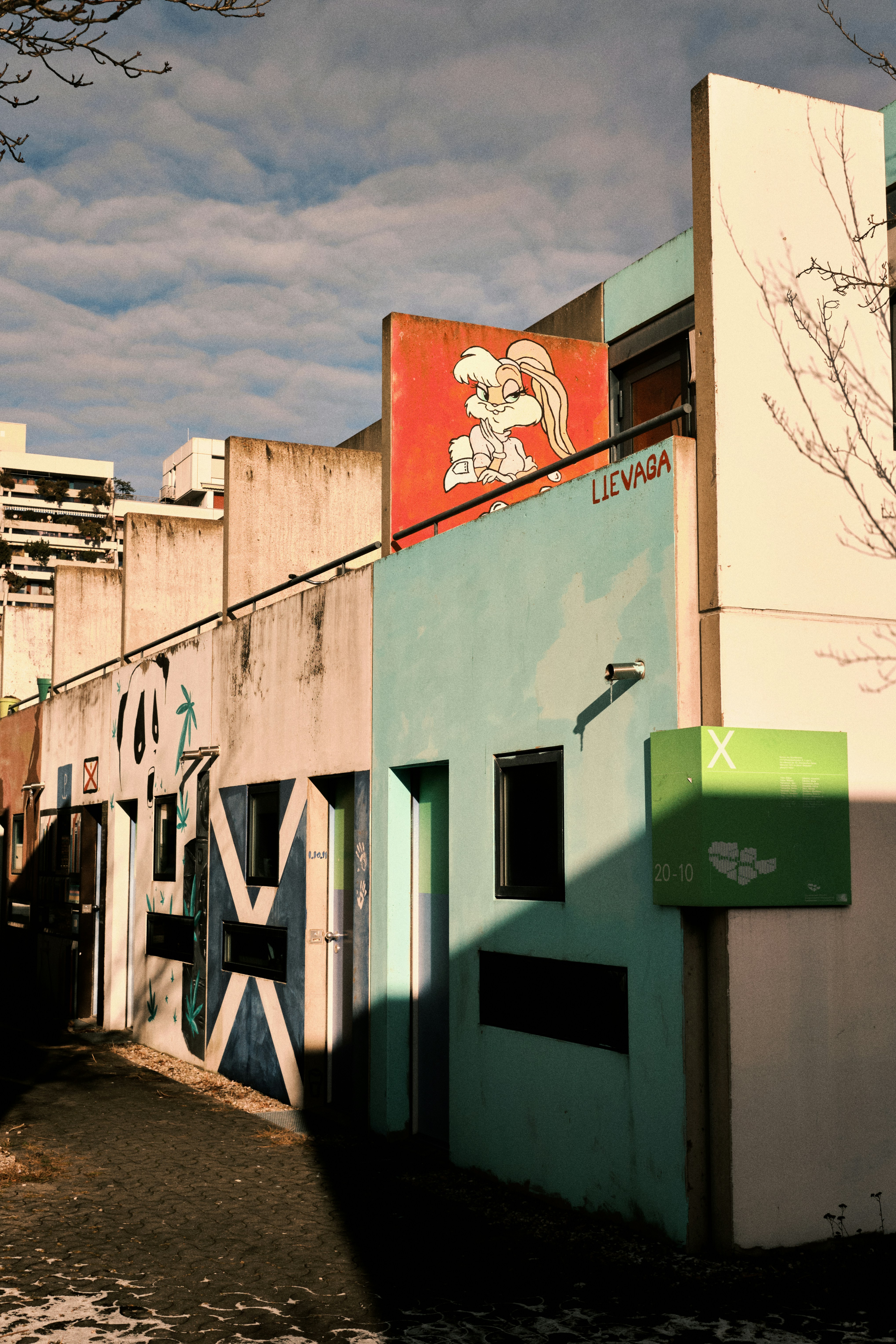 Urban alleyway with colorful buildings and a lola bunny mural.