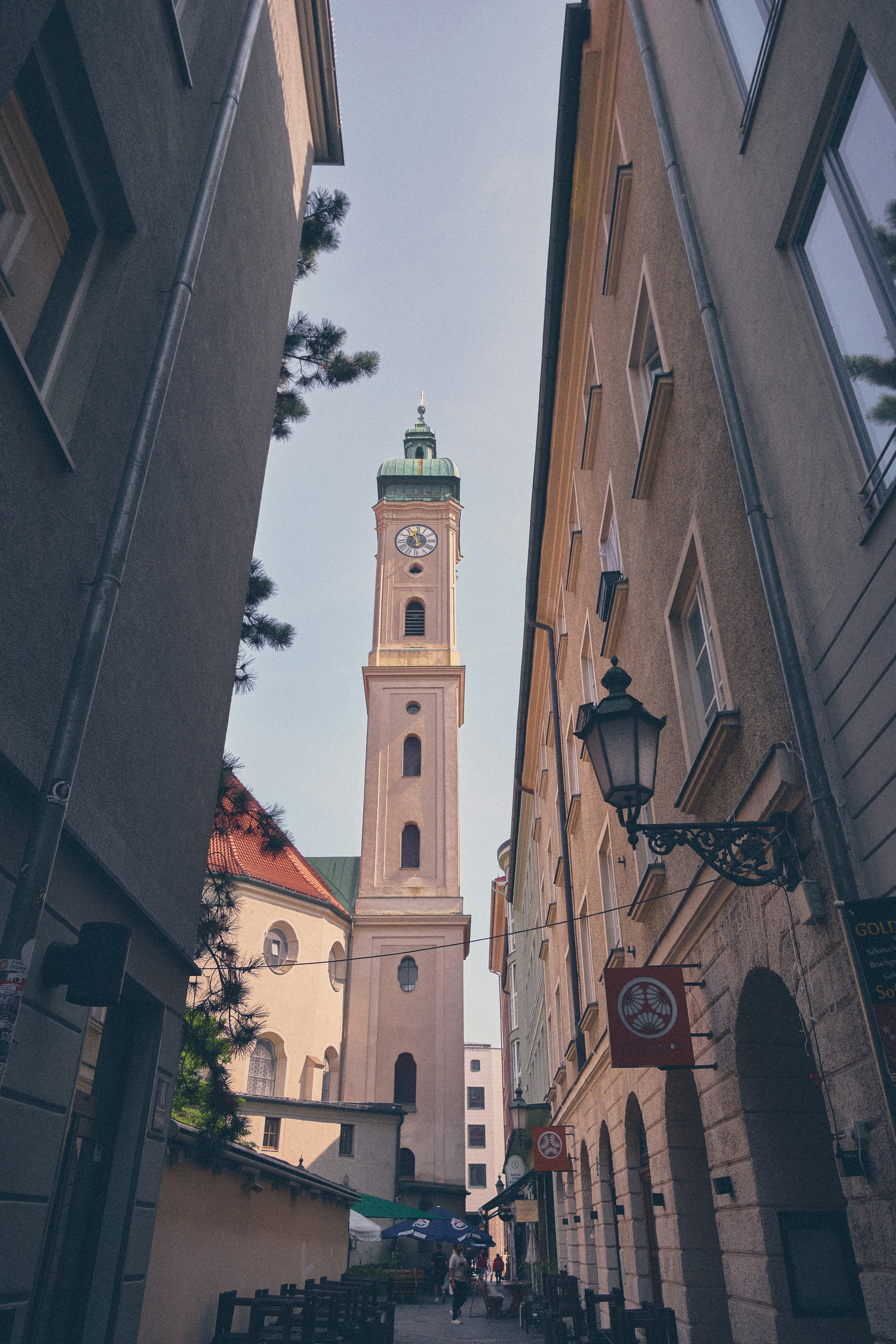 Towering Clock Tower Between Narrow Stuccoed Facades