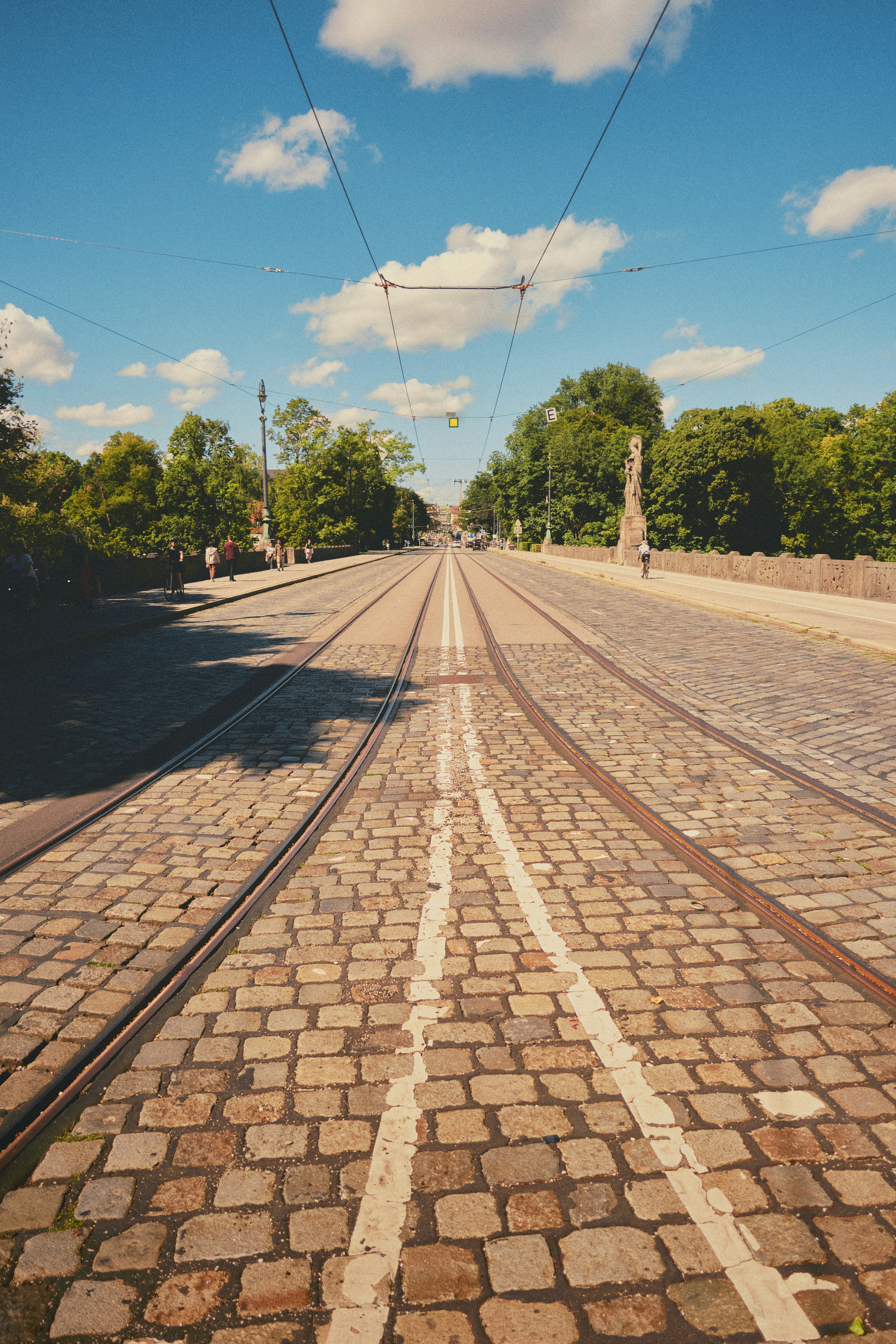 Rails Toward the Horizon: A Sunlit Streetcar Path Through Cobblestones