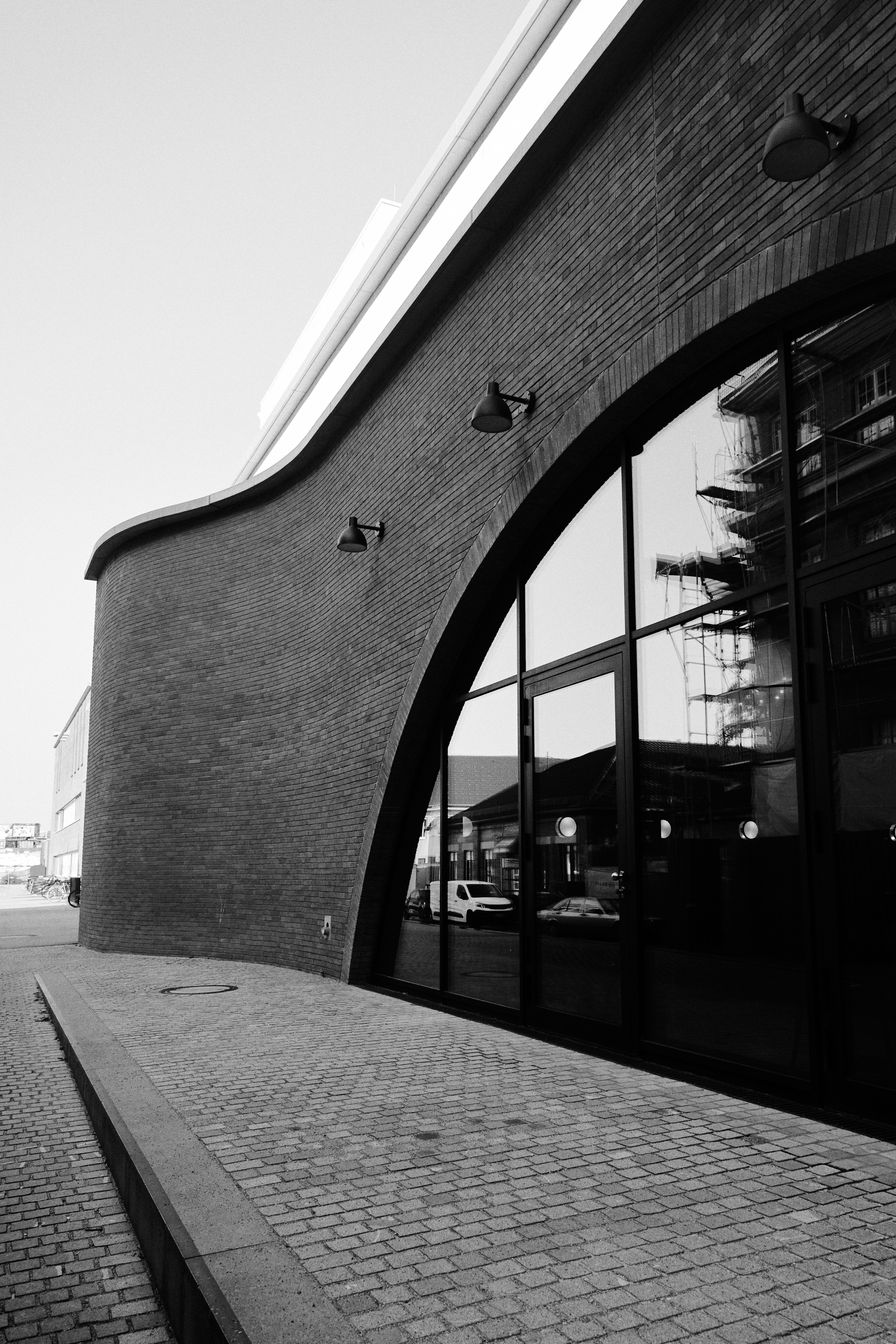 Arched Glass Facade Meets Brick Curve