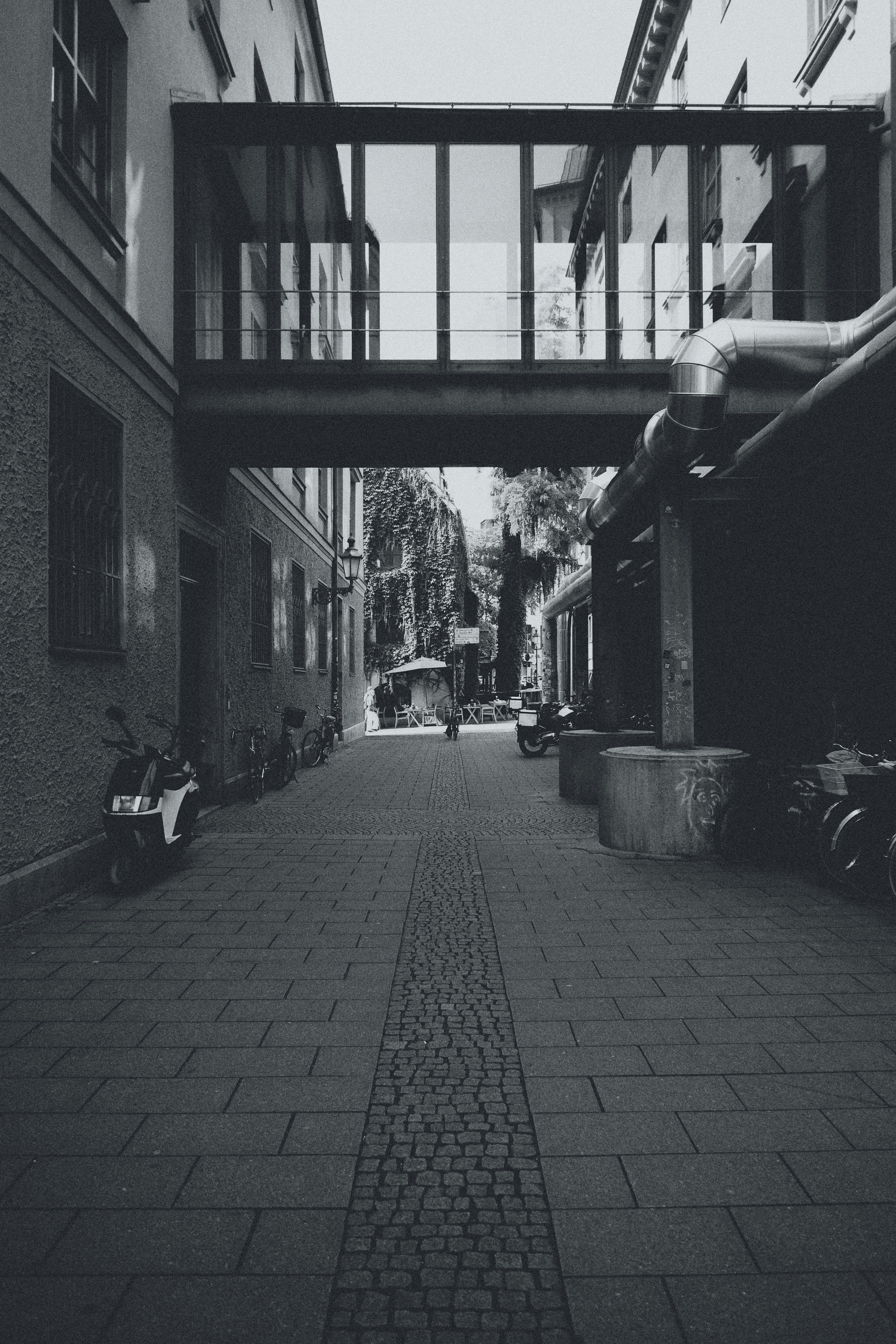 Narrow Alleyway Converging Toward a Distant Café