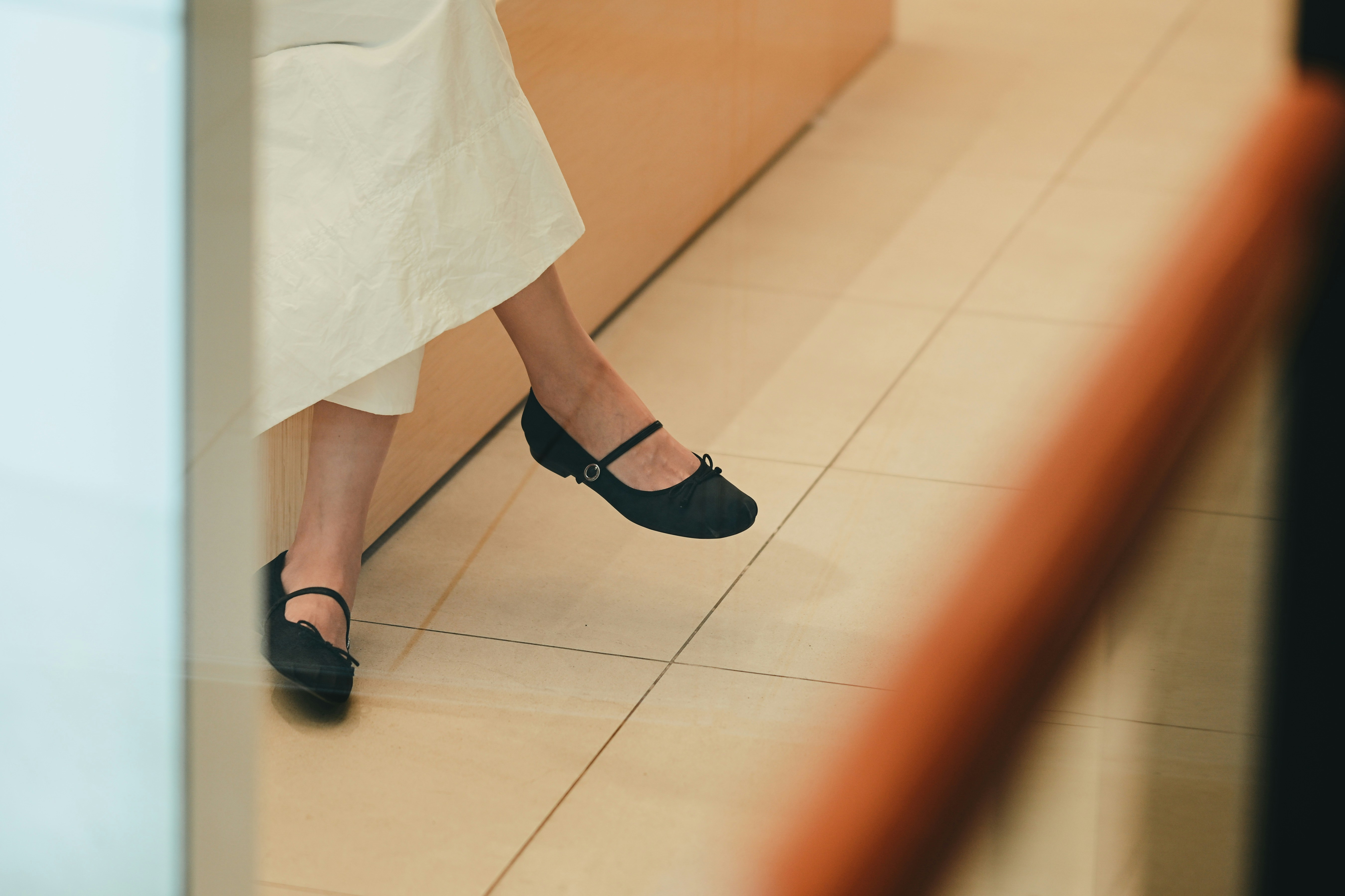 Hidden Steps: A Pair of Shoes in a Sunlit Corridor