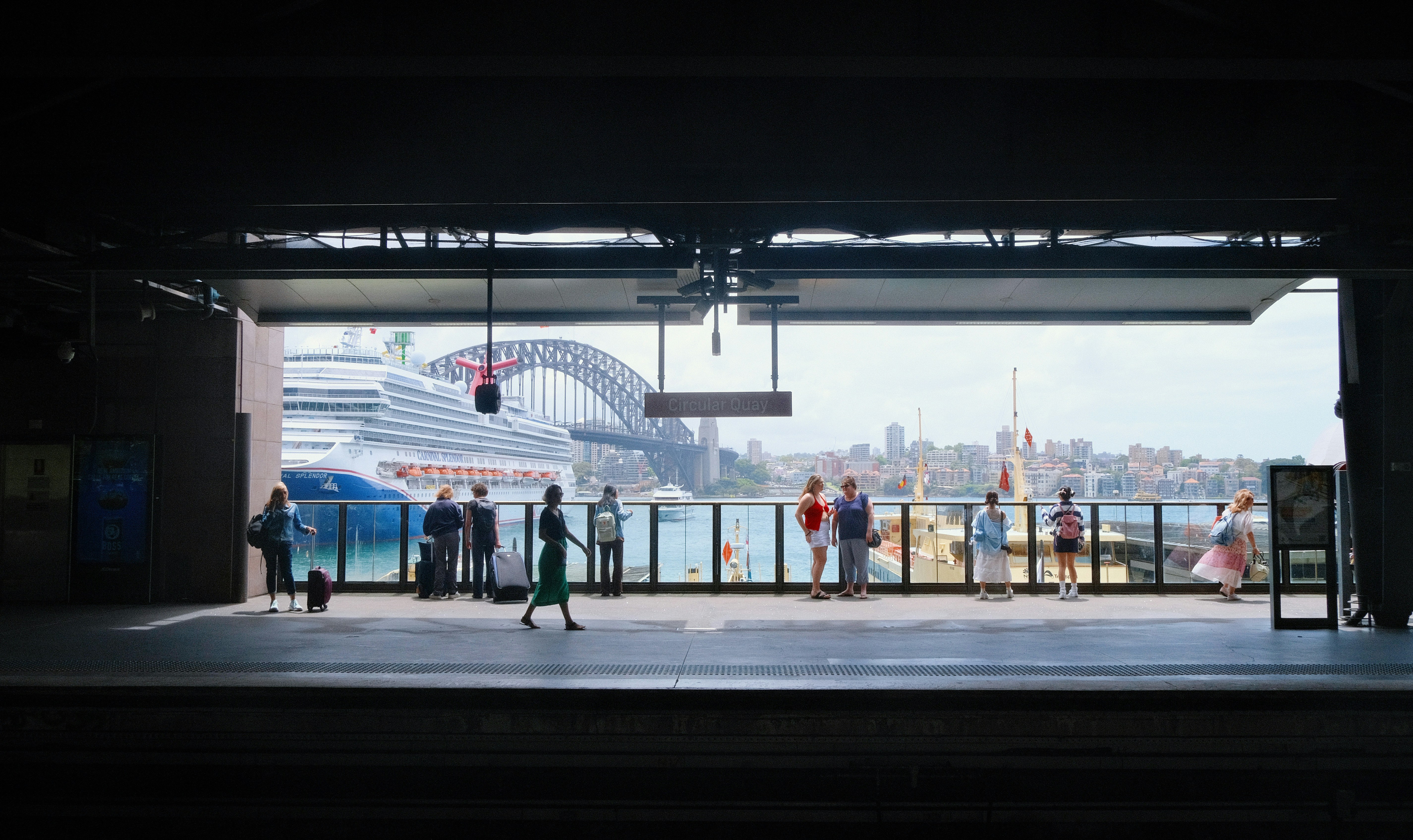Passengers on the Harbour Edge: A Transit Pause with a City Backdrop