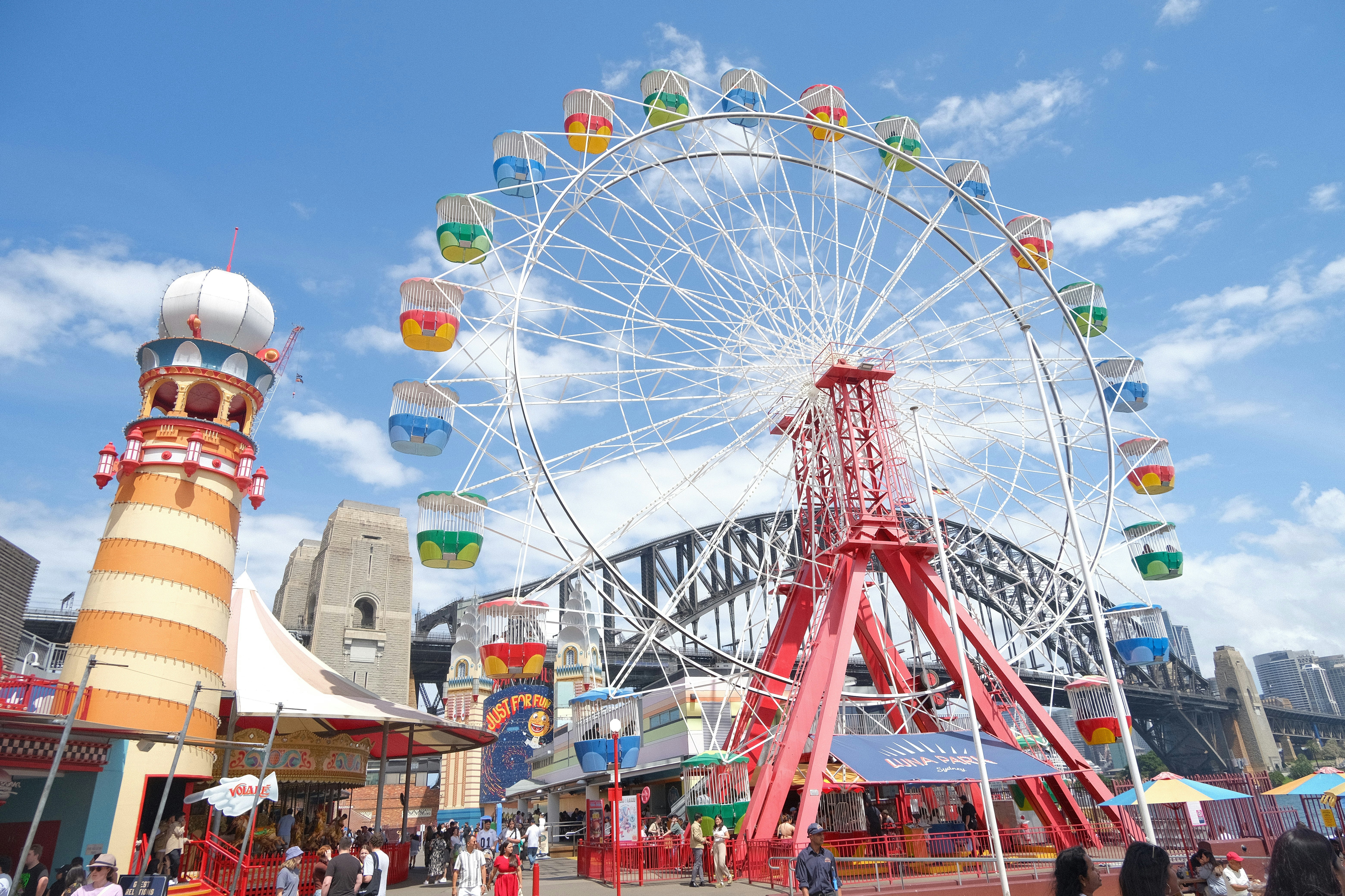 City of Wheels: A Luminous Ferris Wheel Framed by a Candy-Striped Tower