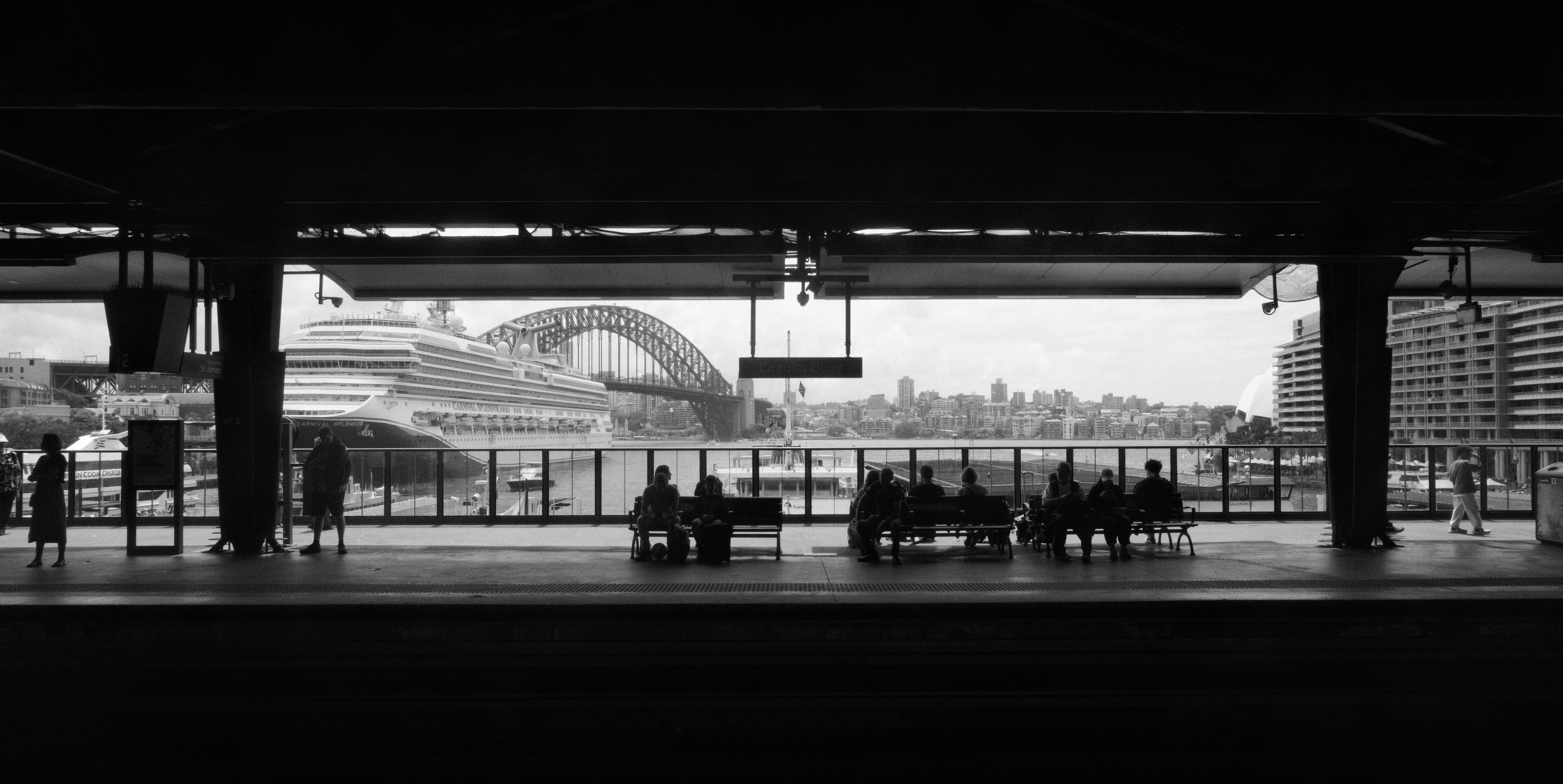 Silhouette on the Platform: Cityscape Across the River